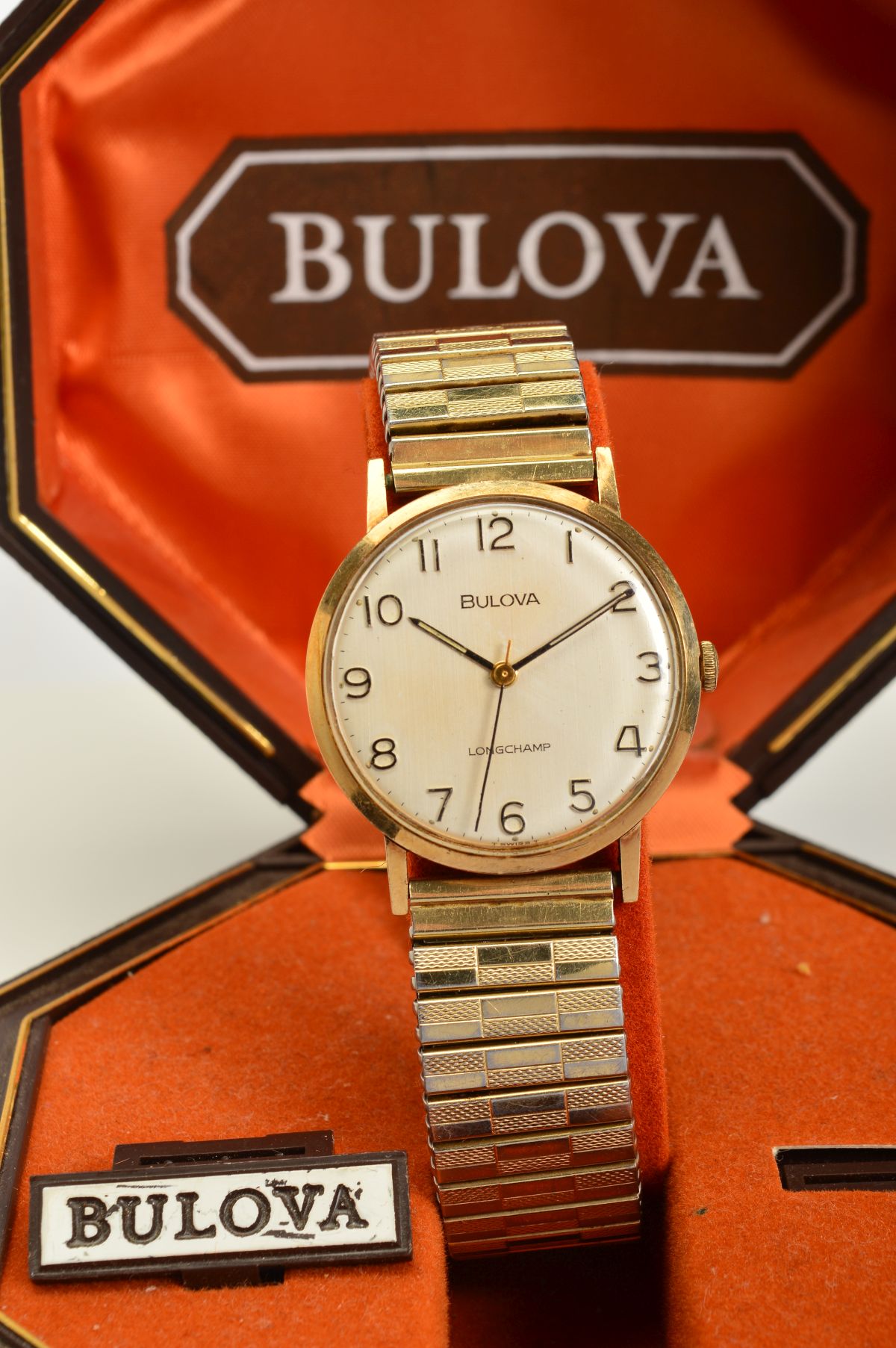 A BOXED 1970'S 9CT GOLD CASED BULOVA LONGCHAMP WRISTWATCH, silvered ...