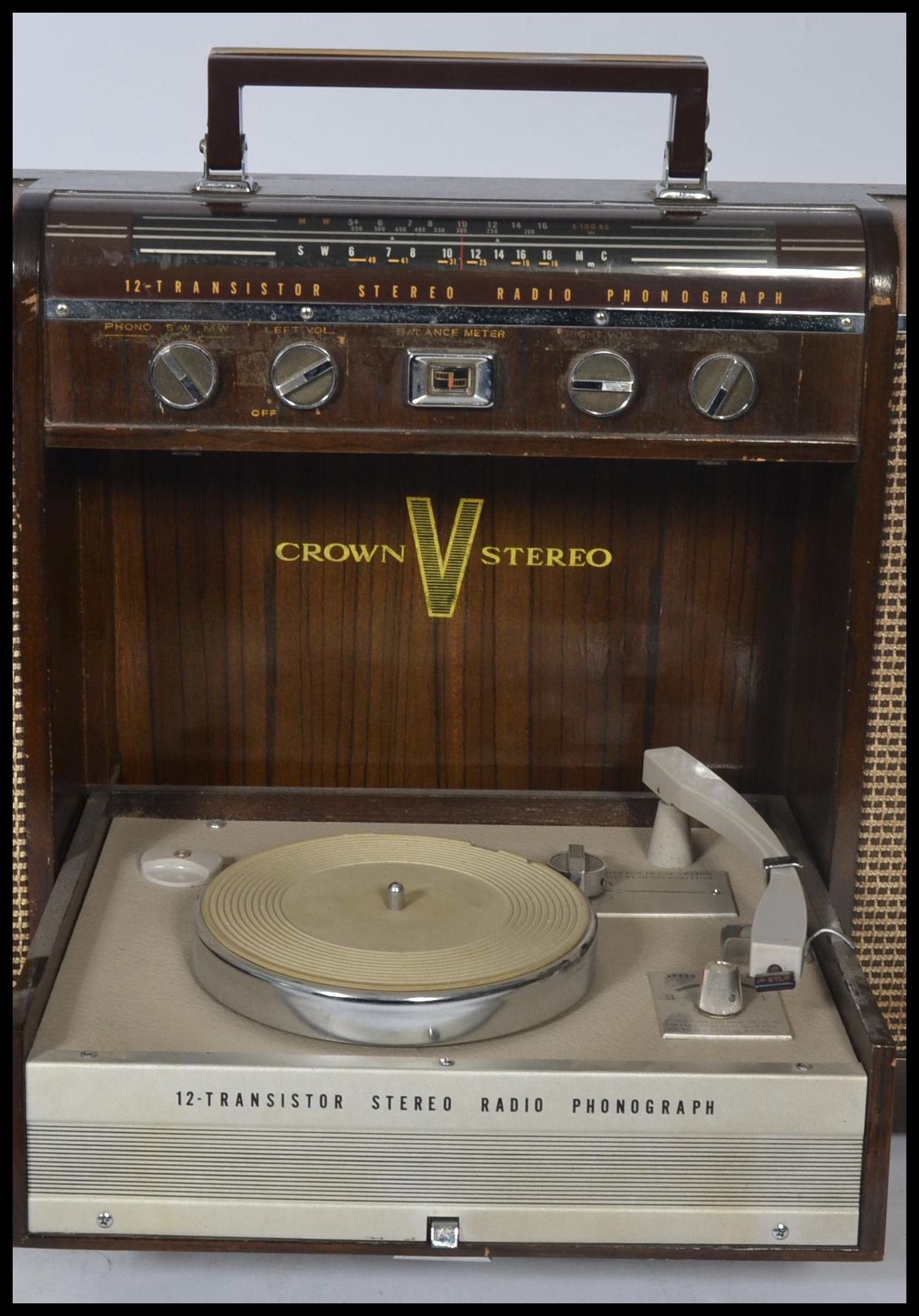 A vintage mid 20th century Crown V stereo 12 transistor stereo radio phonograph record player. Me
