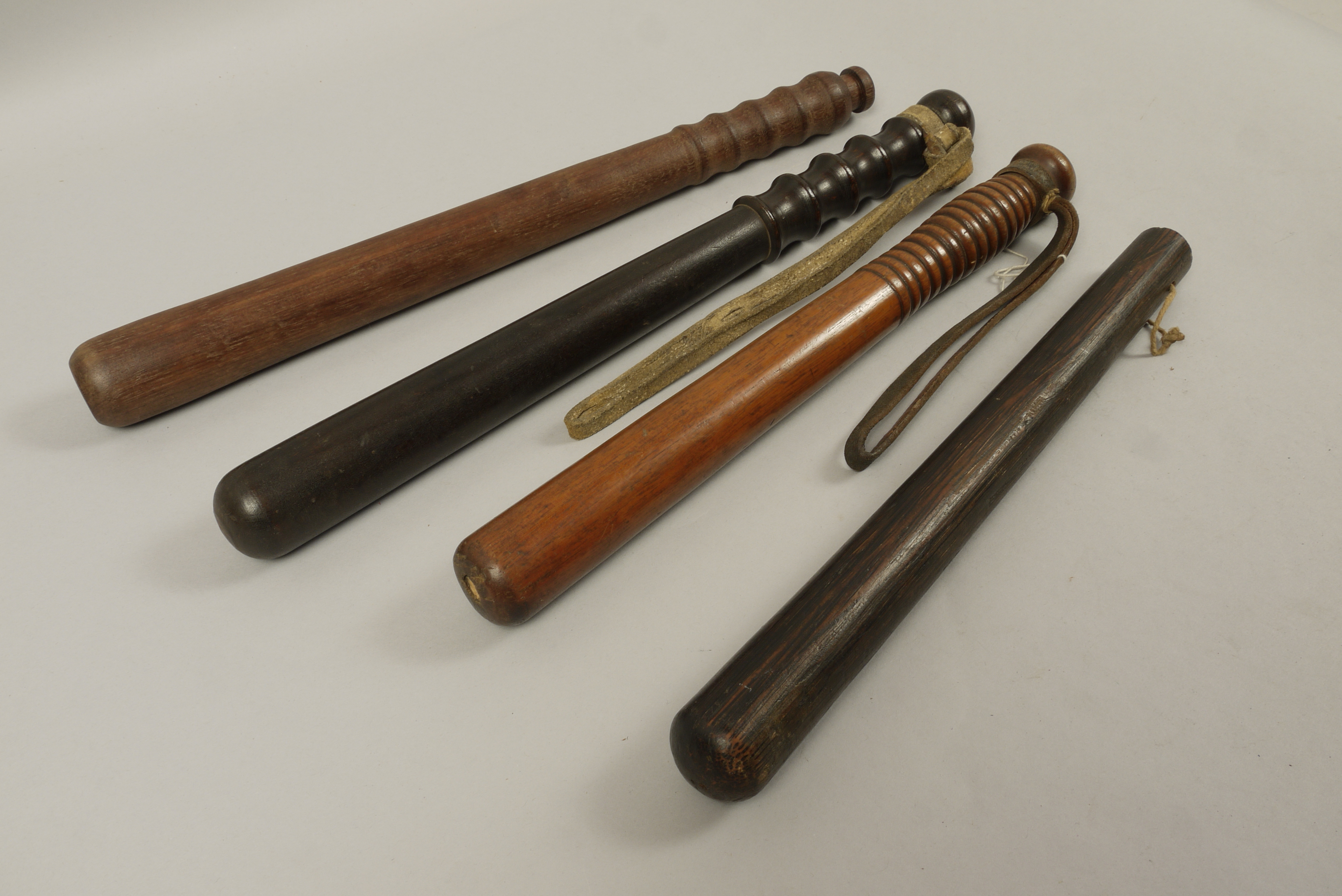 Four vintage truncheons, one palmwood and one faintly marked with rose ...