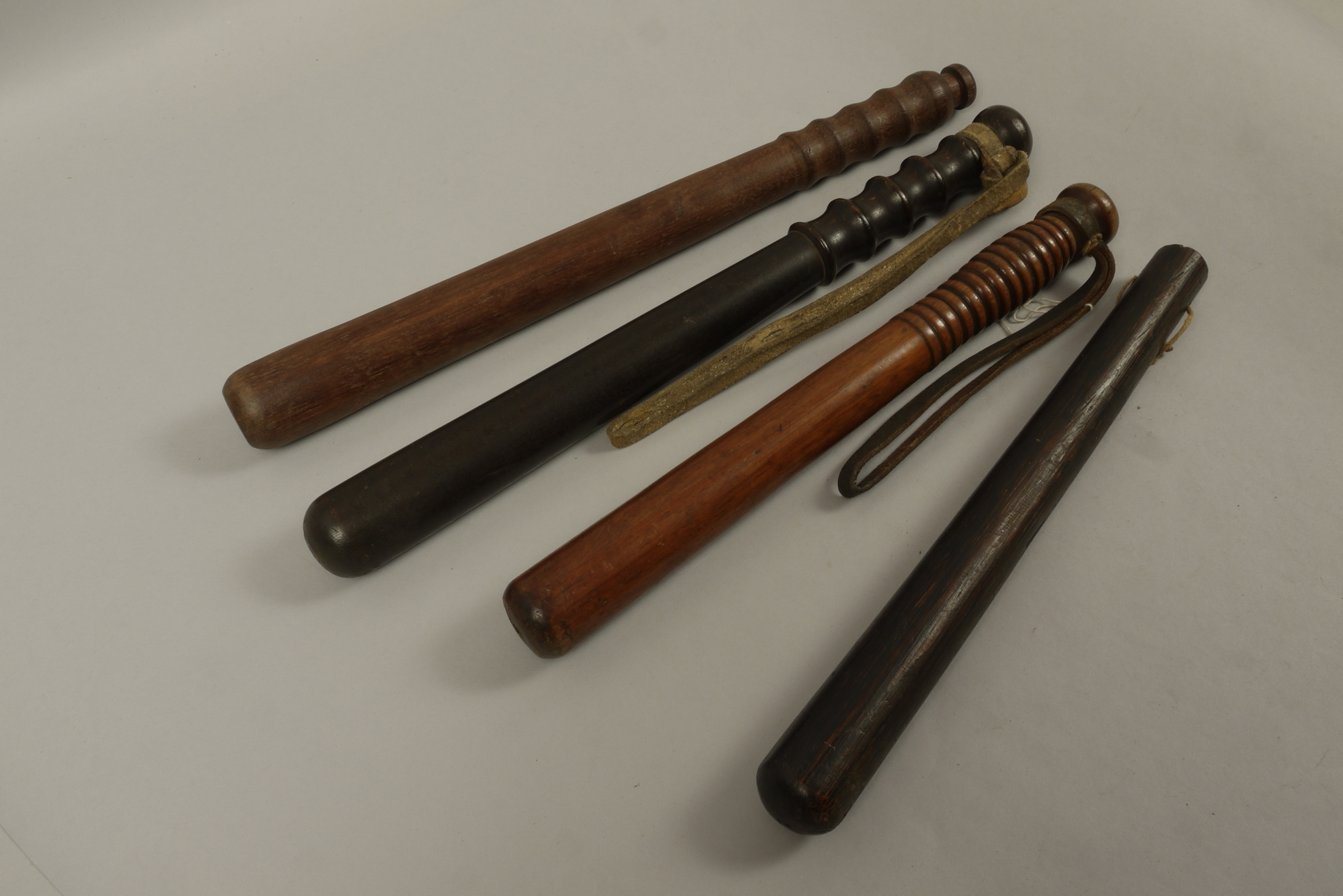 Four vintage truncheons, one palmwood and one faintly marked with rose ...