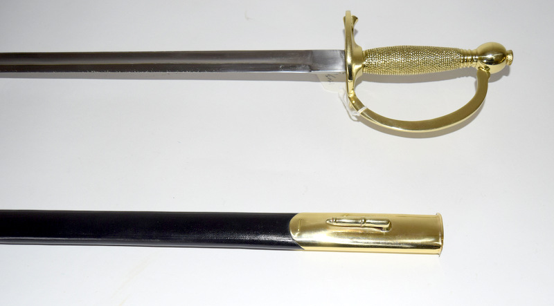 A single edged sword with gilt hilt and knuckle guard in its scabbard ...