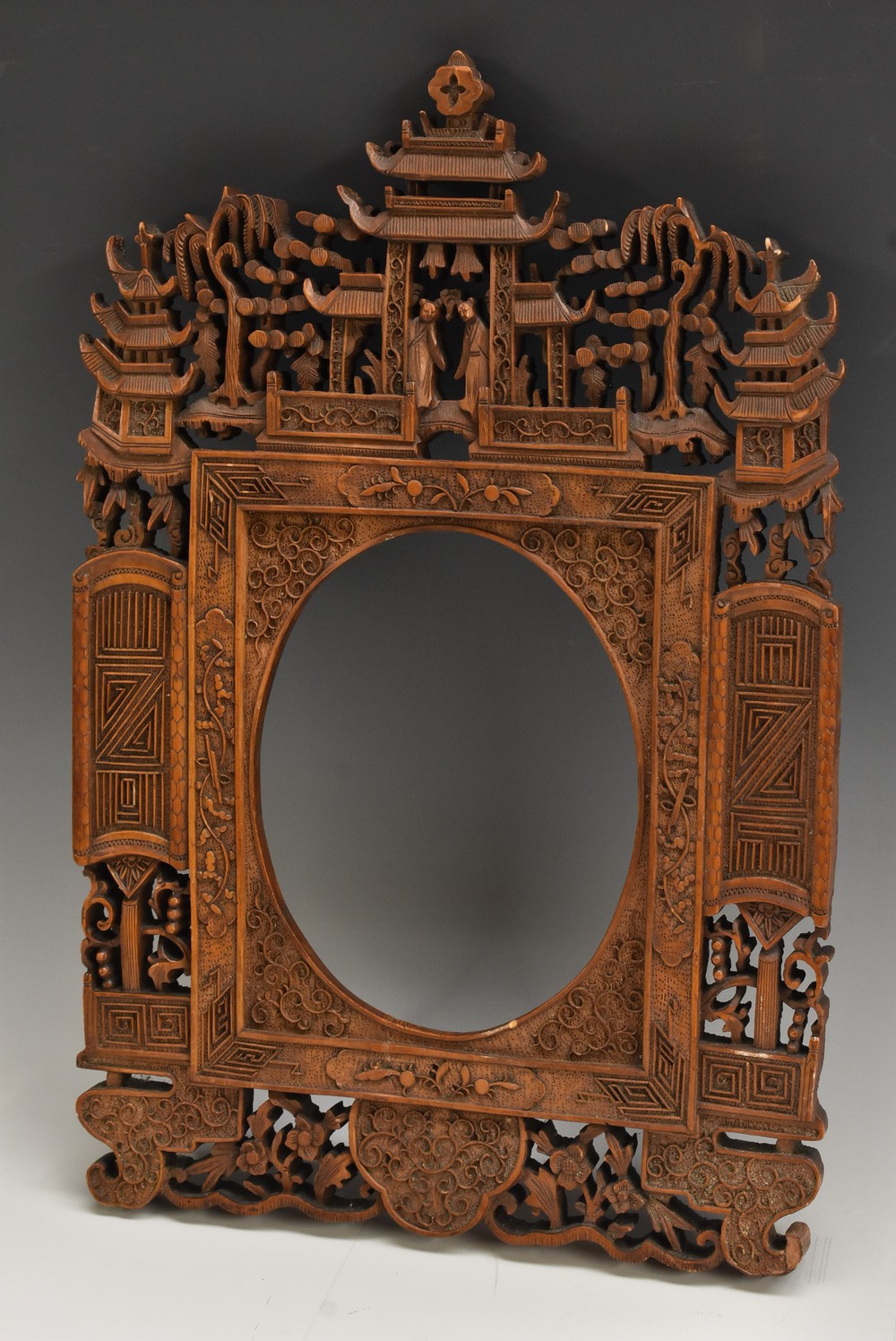 An Chinese carved wooden photograph frame, the crest with pagodas ...