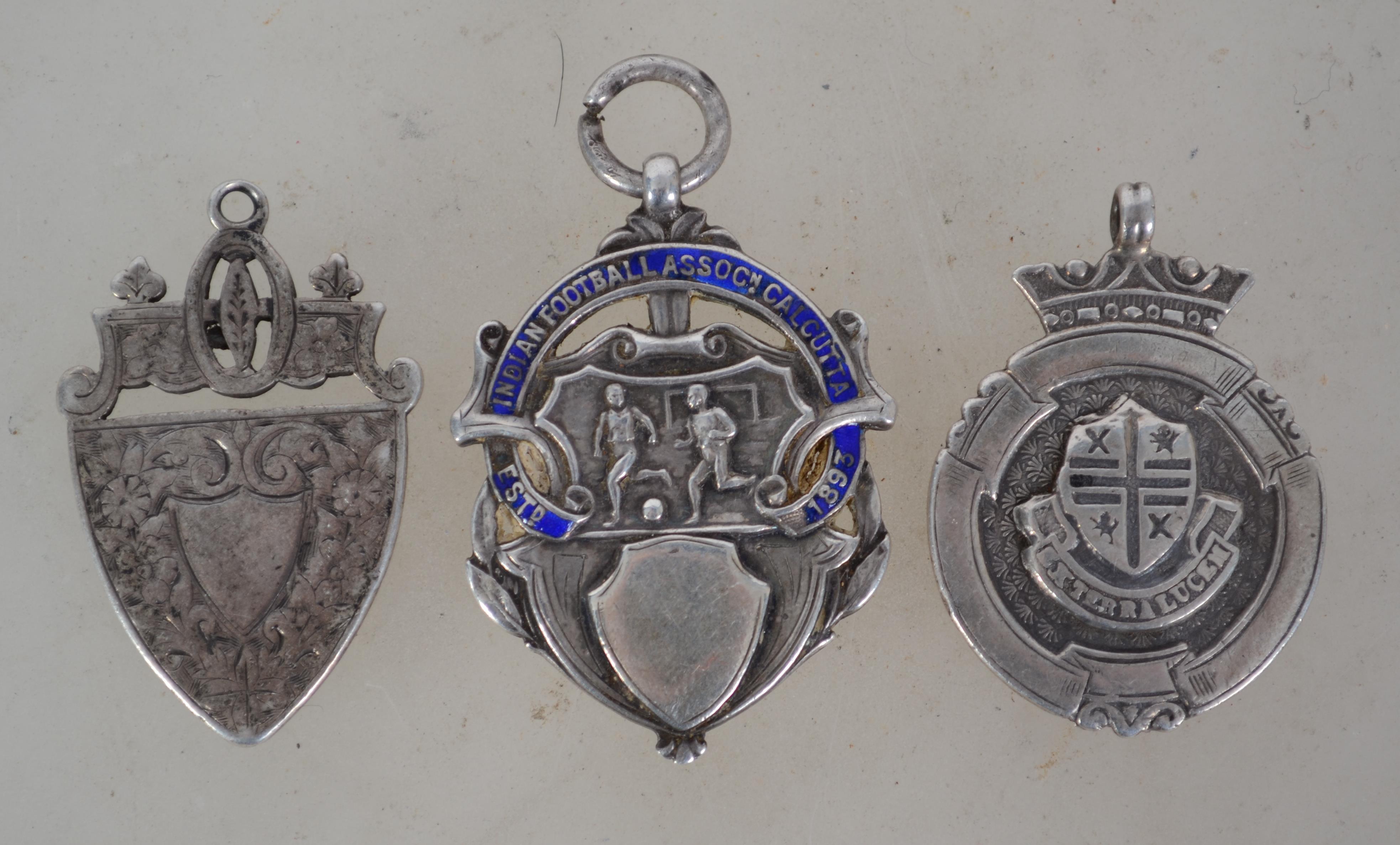 A collection of 3 silver armorial fob shields being hallmarked to ...