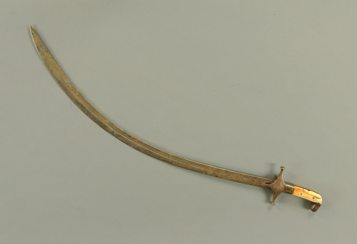 An antique Arabian Scimitar, with bone handle and decorated blade ...