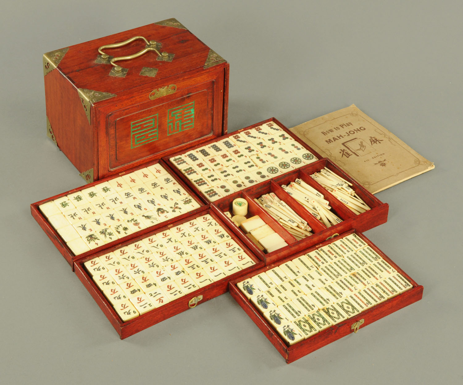 A cased mahjong set, each piece bamboo backed, 148 pieces including 8 ...