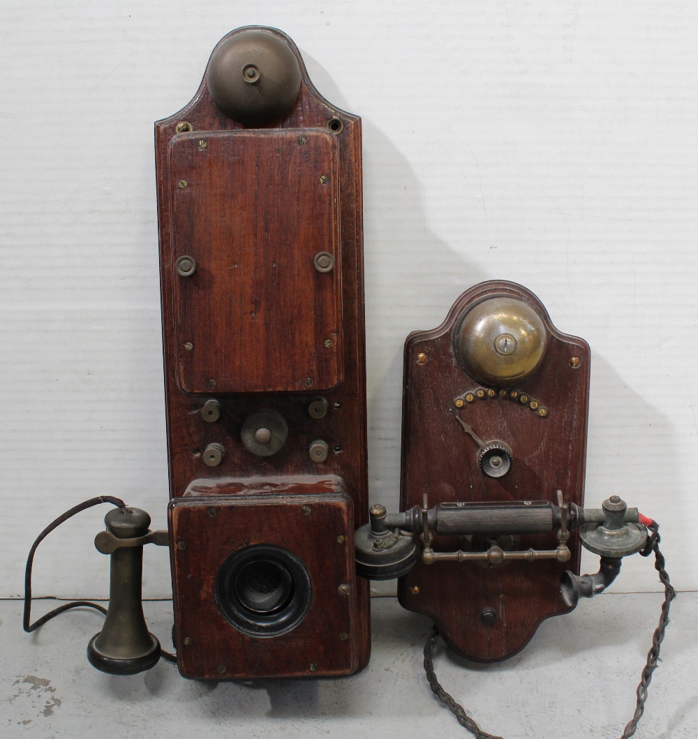 A wall-mounted early 20th century telephone, metal receiver with ...