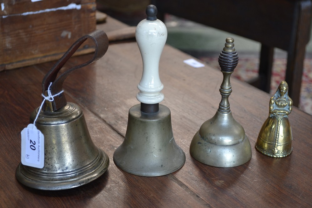 Three 18th century brass hand bells; a brass bell in the form of a lady (4)
