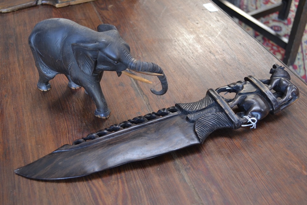A carved wooden Indian elephant and lion knife; an elephant with ...
