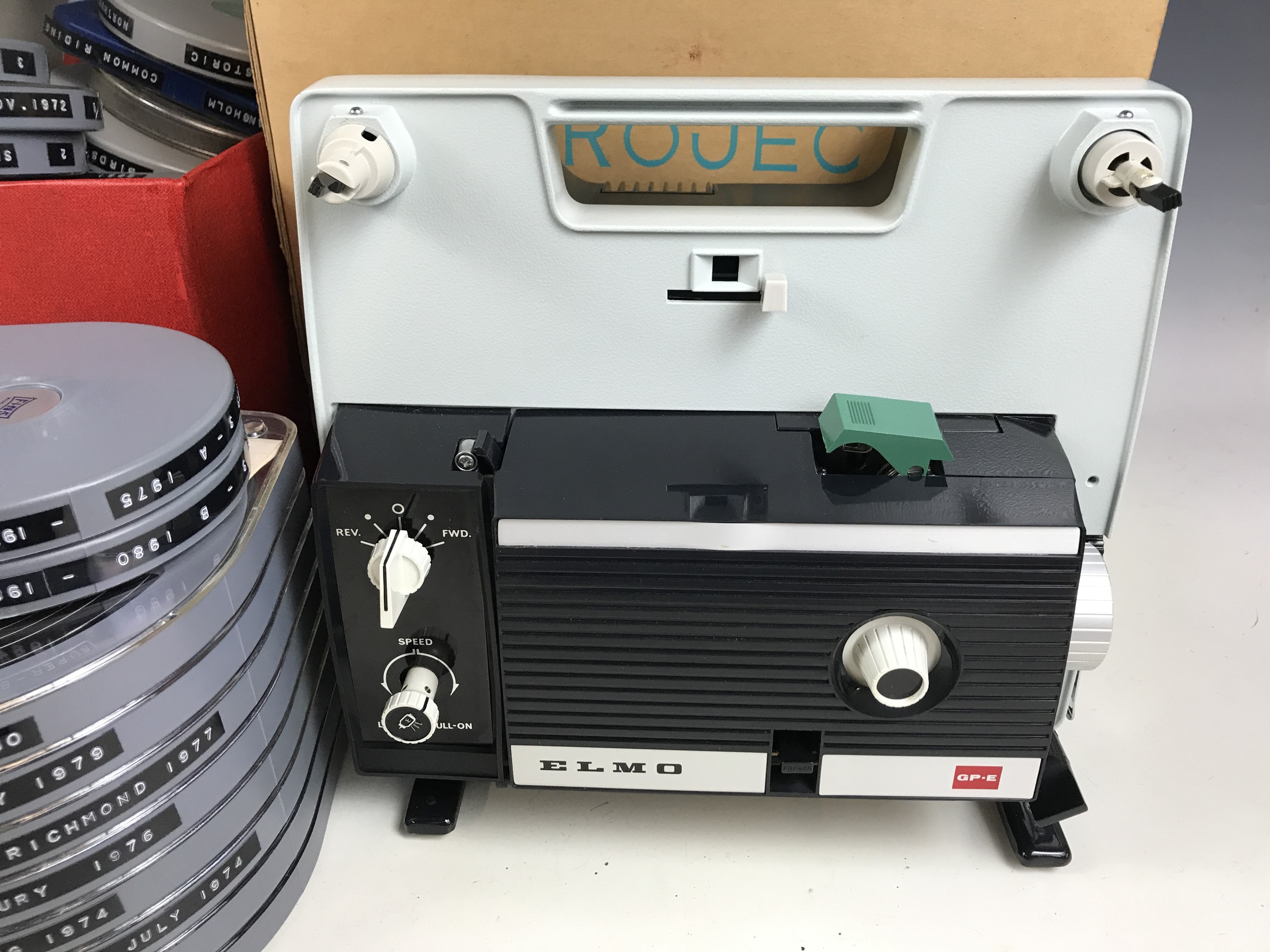 An Elmo GP-E 8mm projector together with a quantity of film reels