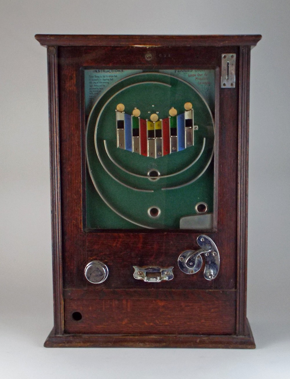 An early 20th century oak cased wall mounted upright pinball machine ...