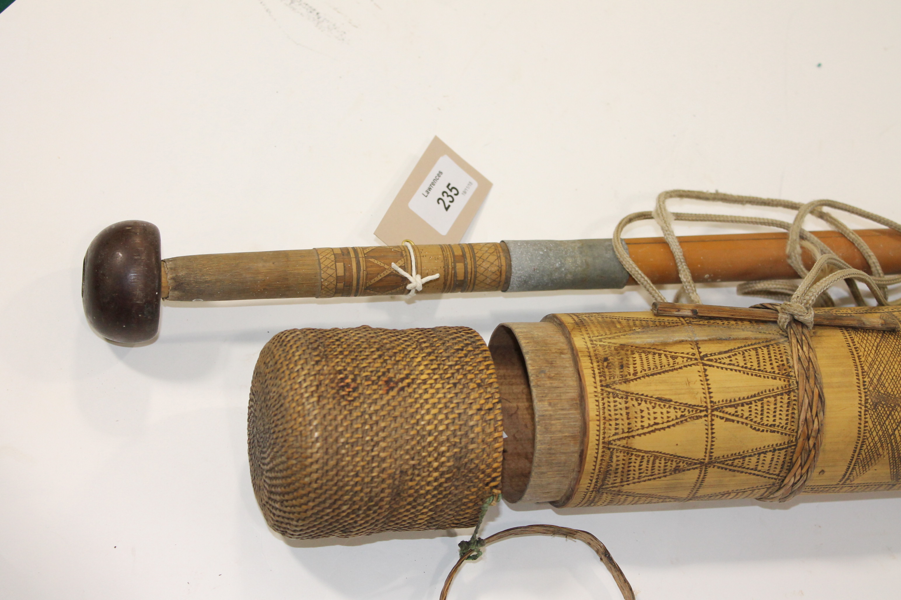 A BLOWPIPE AND DARTS. A natives long blowpipe complete with darts in a ...