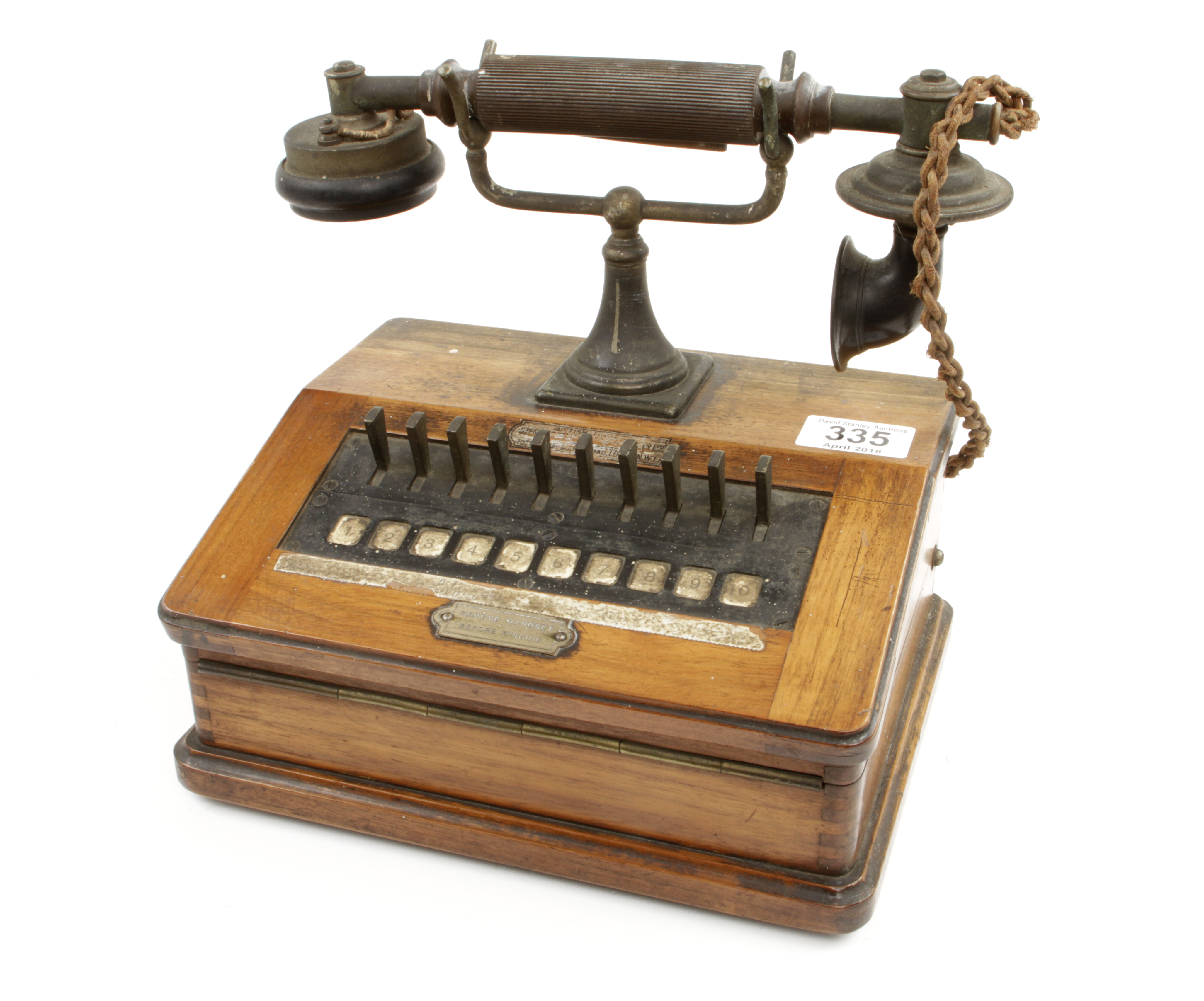 An early cradle telephone with ten numbers with illegible company label ...