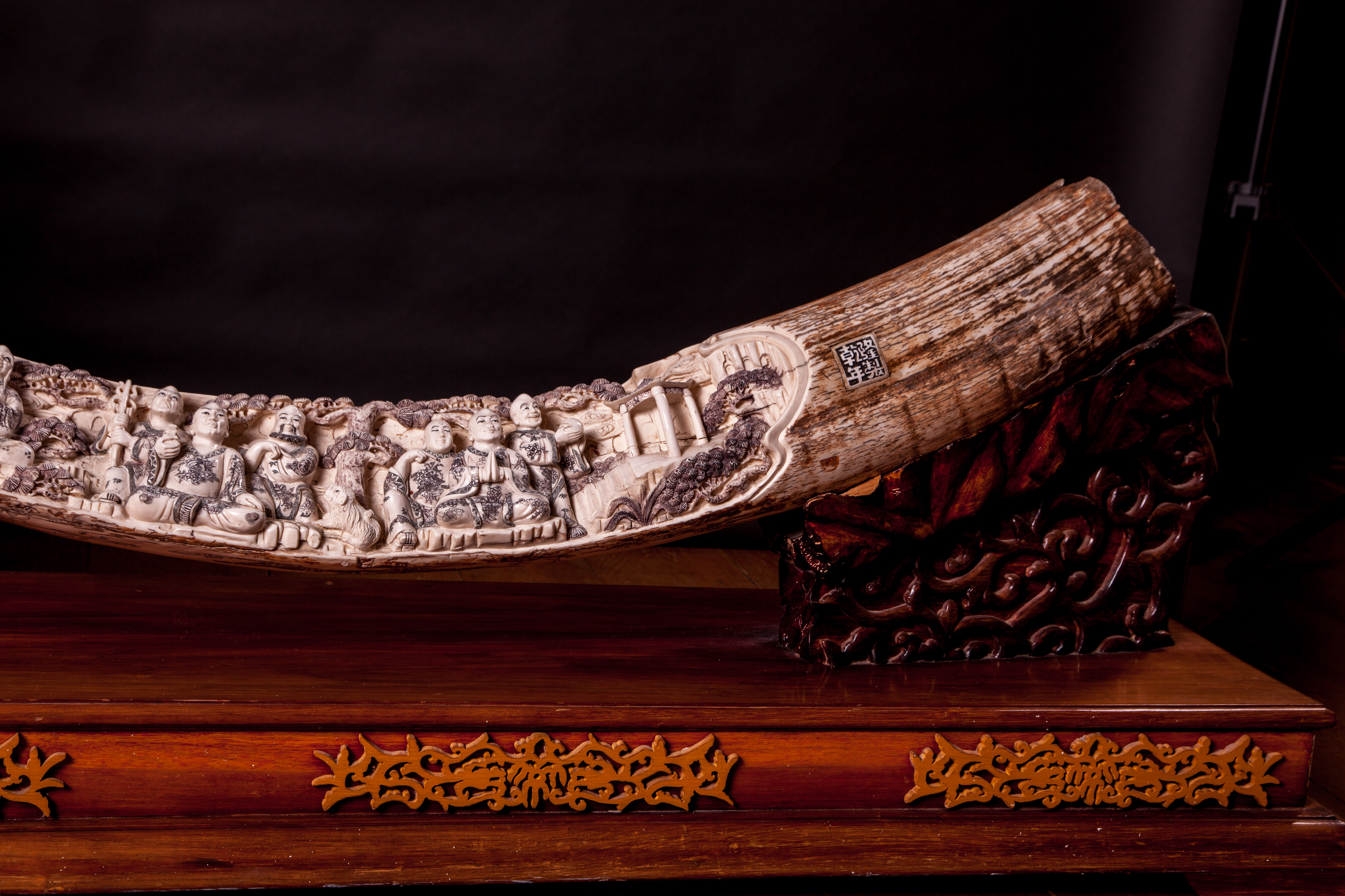 A mammoth tusk, highly carved in relief with depictions of many monks ...