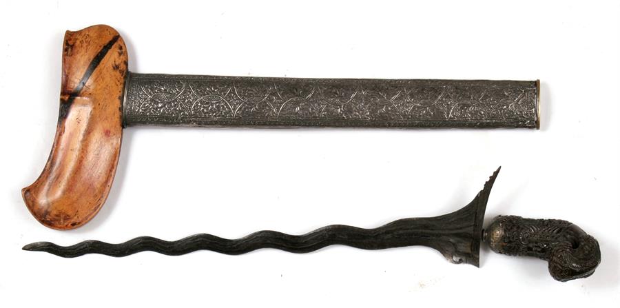An Indonesian Kris dagger with wavy ornate blade and intricately carved ...