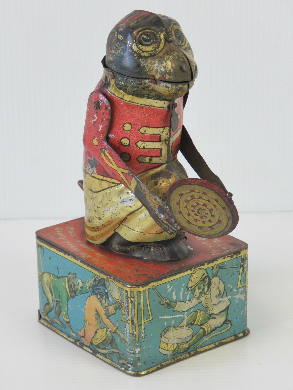 A rare tin plate monkey money box with moving arms and mouth, bearing ...