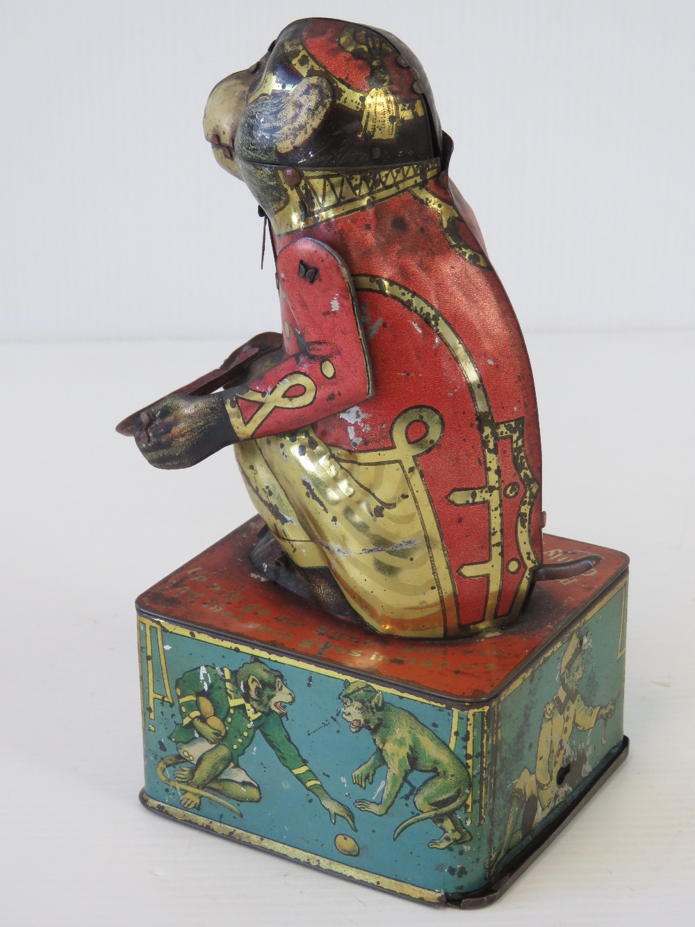 A rare tin plate monkey money box with moving arms and mouth, bearing ...