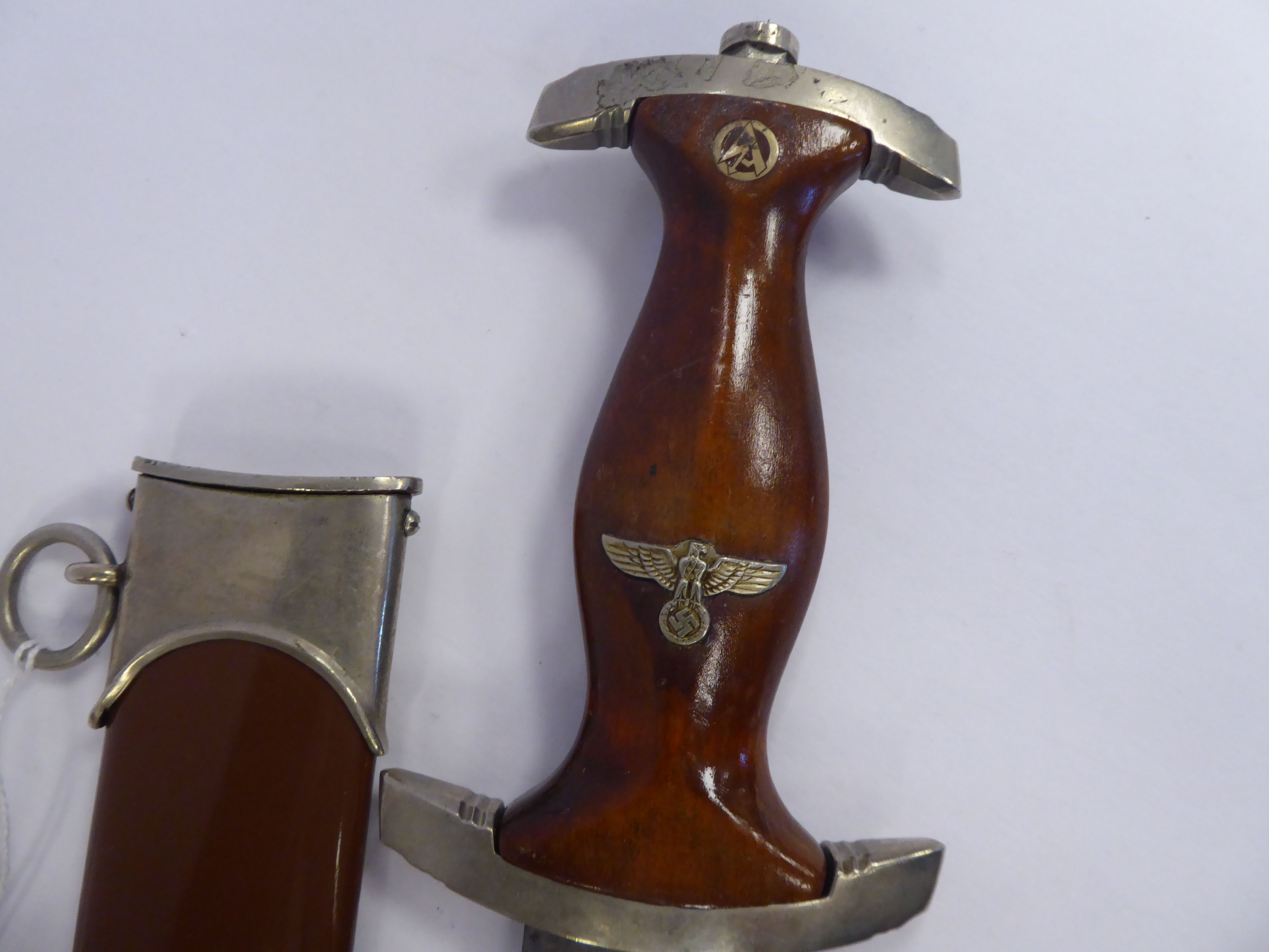 A German SA dagger with a carved brown stained wooden handgrip and a ...