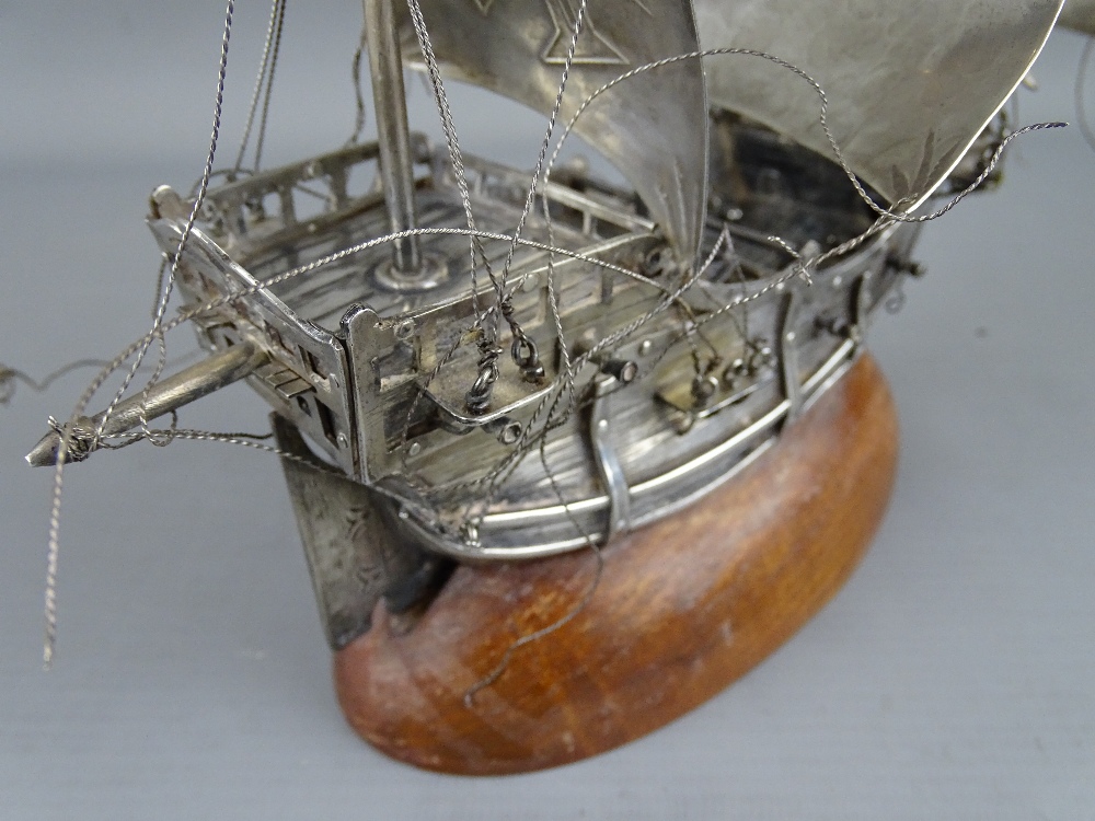 A PORTUGUESE SILVER GALLEON mounted on a wooden base, stamped to the ...