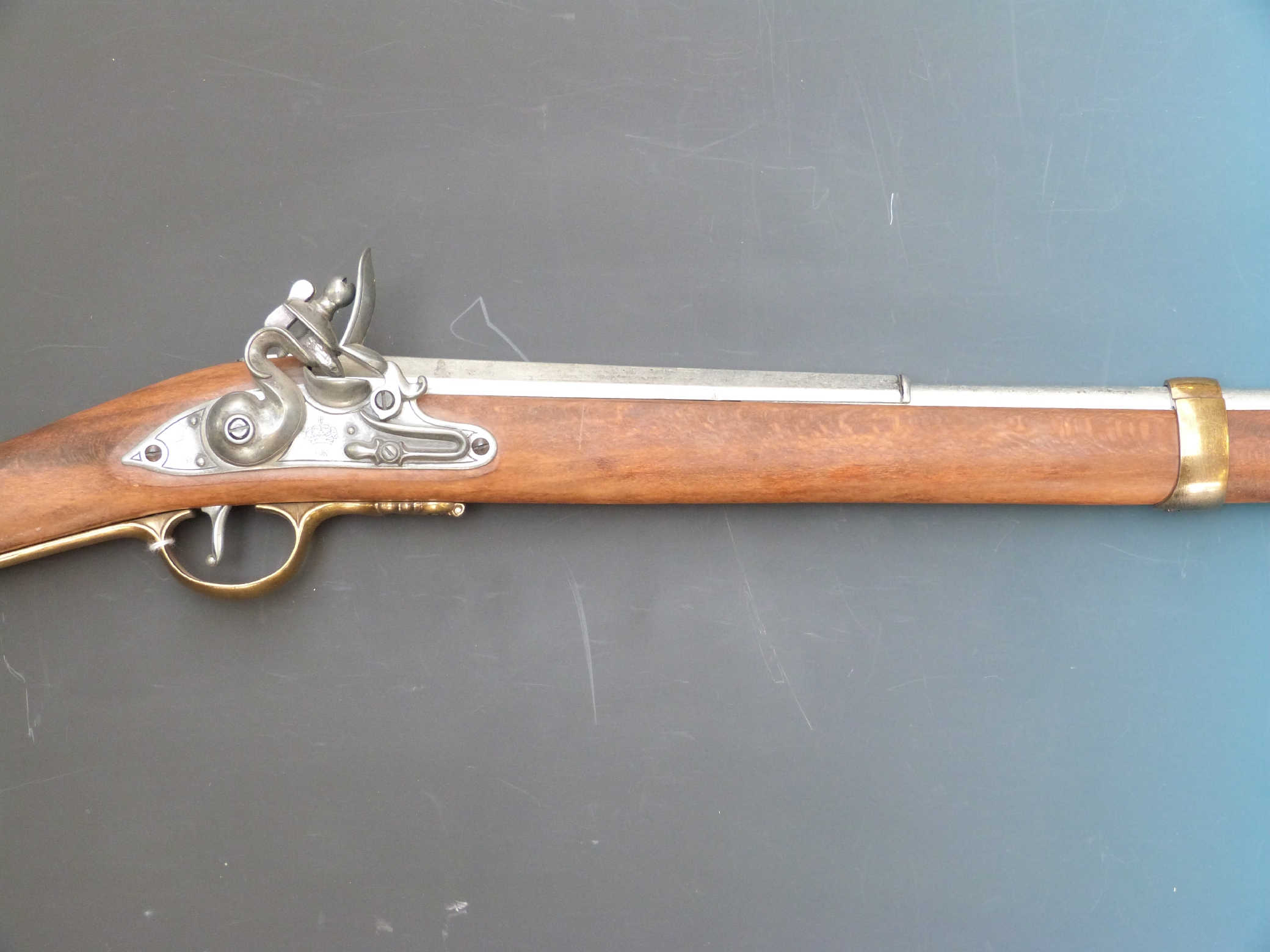 A replica 19thC flintlock rifle, the lock marked "Tower" and "GR" under ...