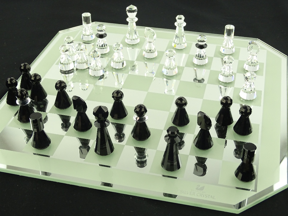 A Swarovski silver crystal chess set and board, cased.