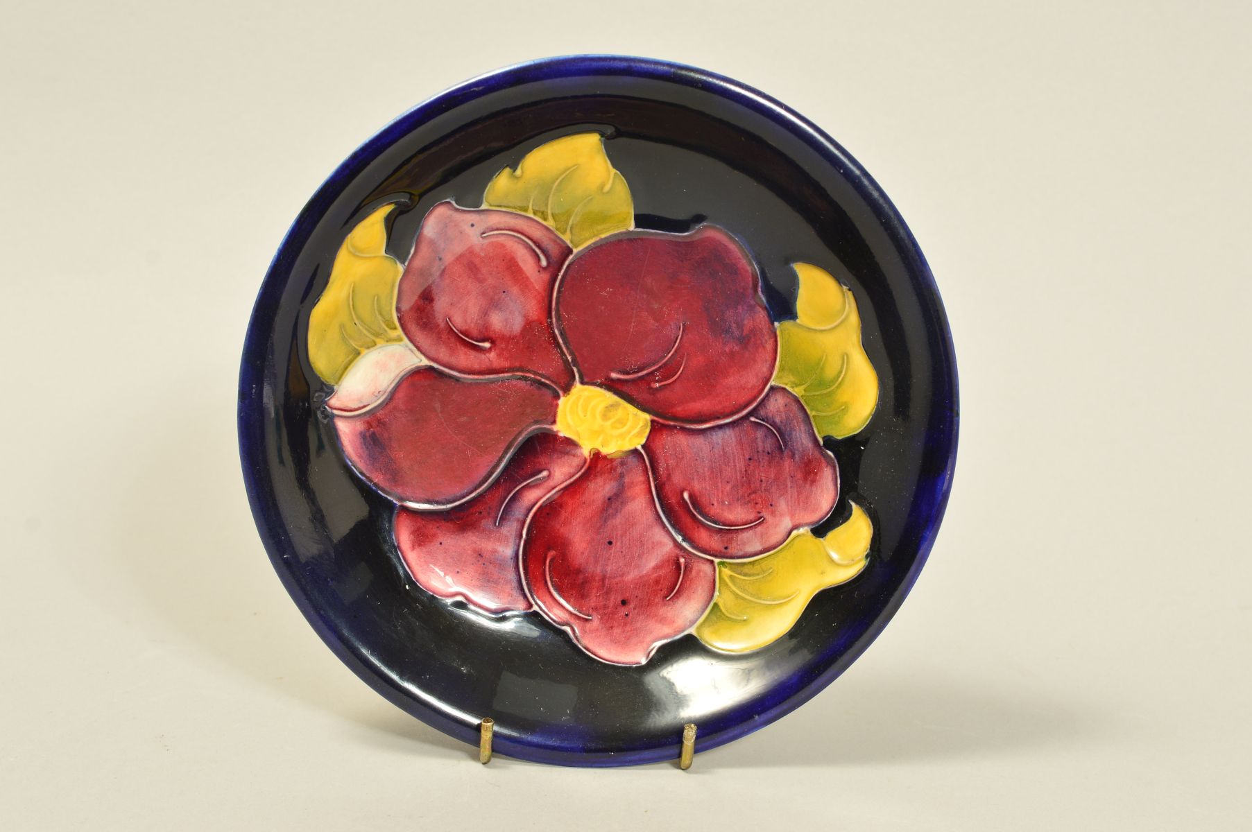 A MOORCROFT POTTERY DISH, 'Clematis' pattern on blue ground, impressed ...