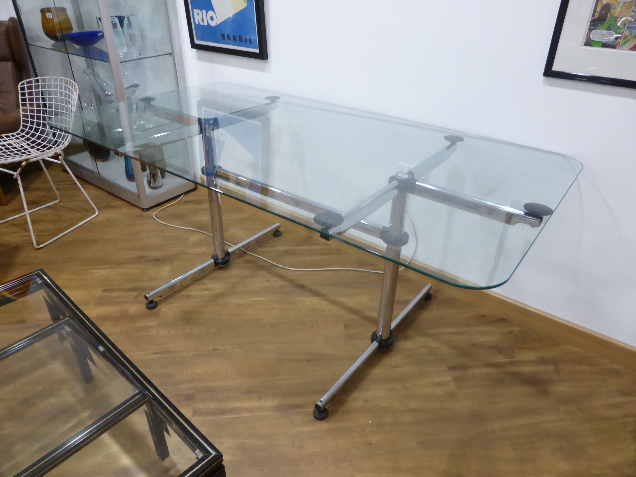 A USM Haller 'Kitos' adjustable table with a harlequin glass top, l ...