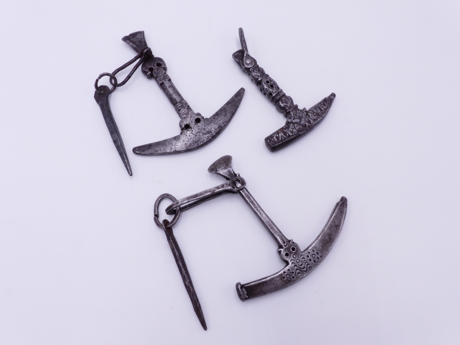 THREE IRON FLINT KNAPPING HAMMERS, TWO WITH CARVED AND ENGRAVED ...