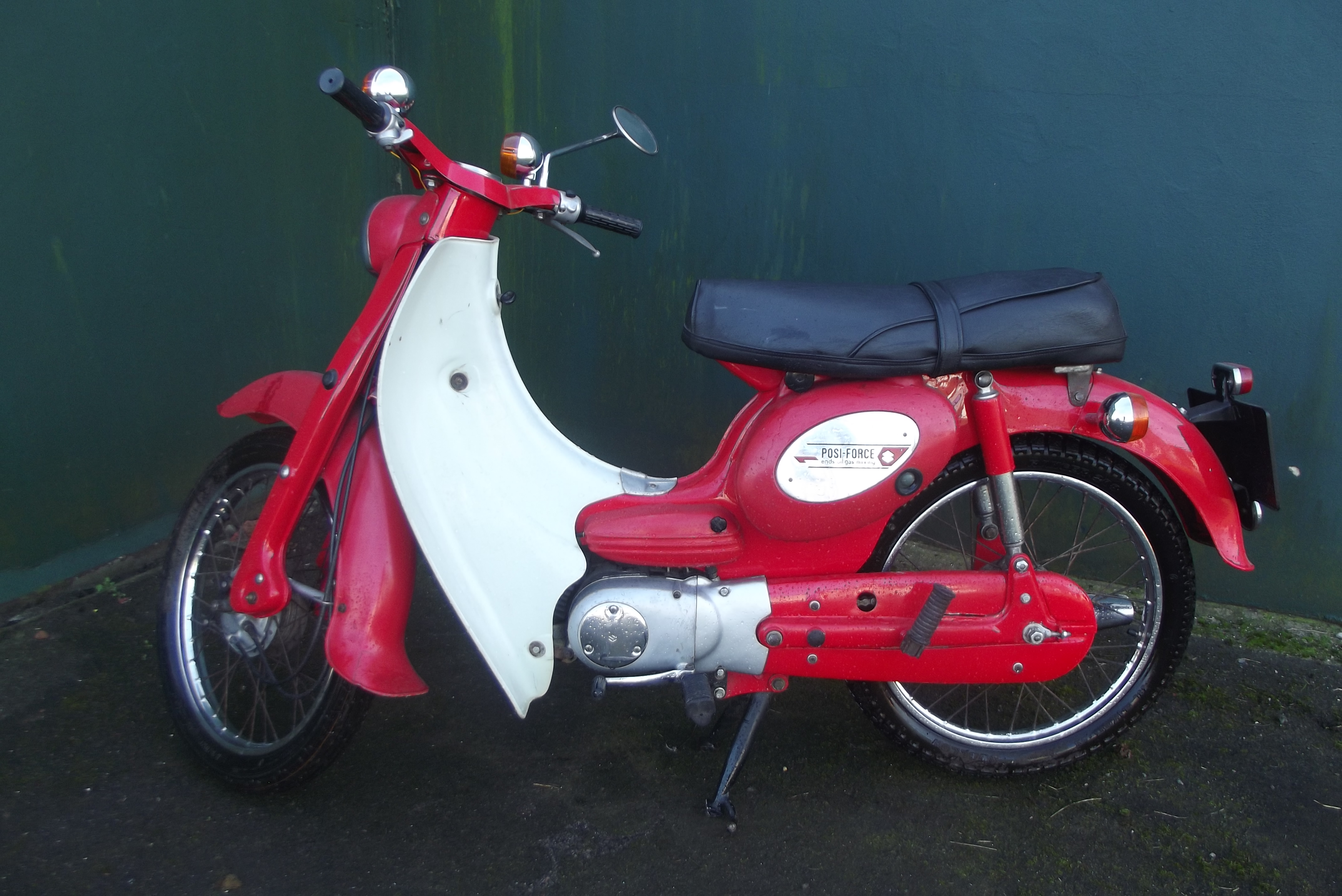 A 1970 Suzuki U50 Step Through, registration number HGL 977H, red. A ...