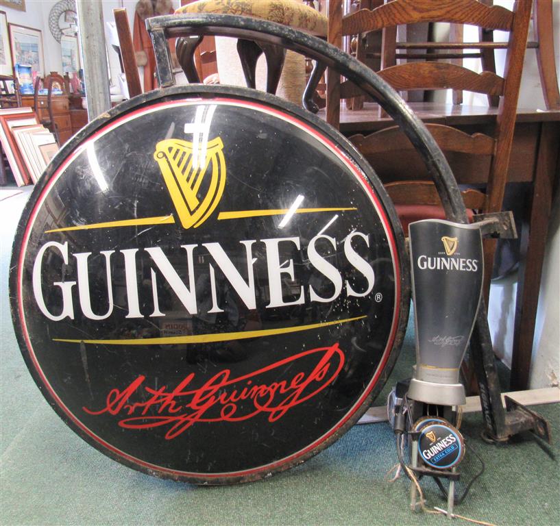 A large Guinness sign complete with hanging bracket. Diameter 80cms ...