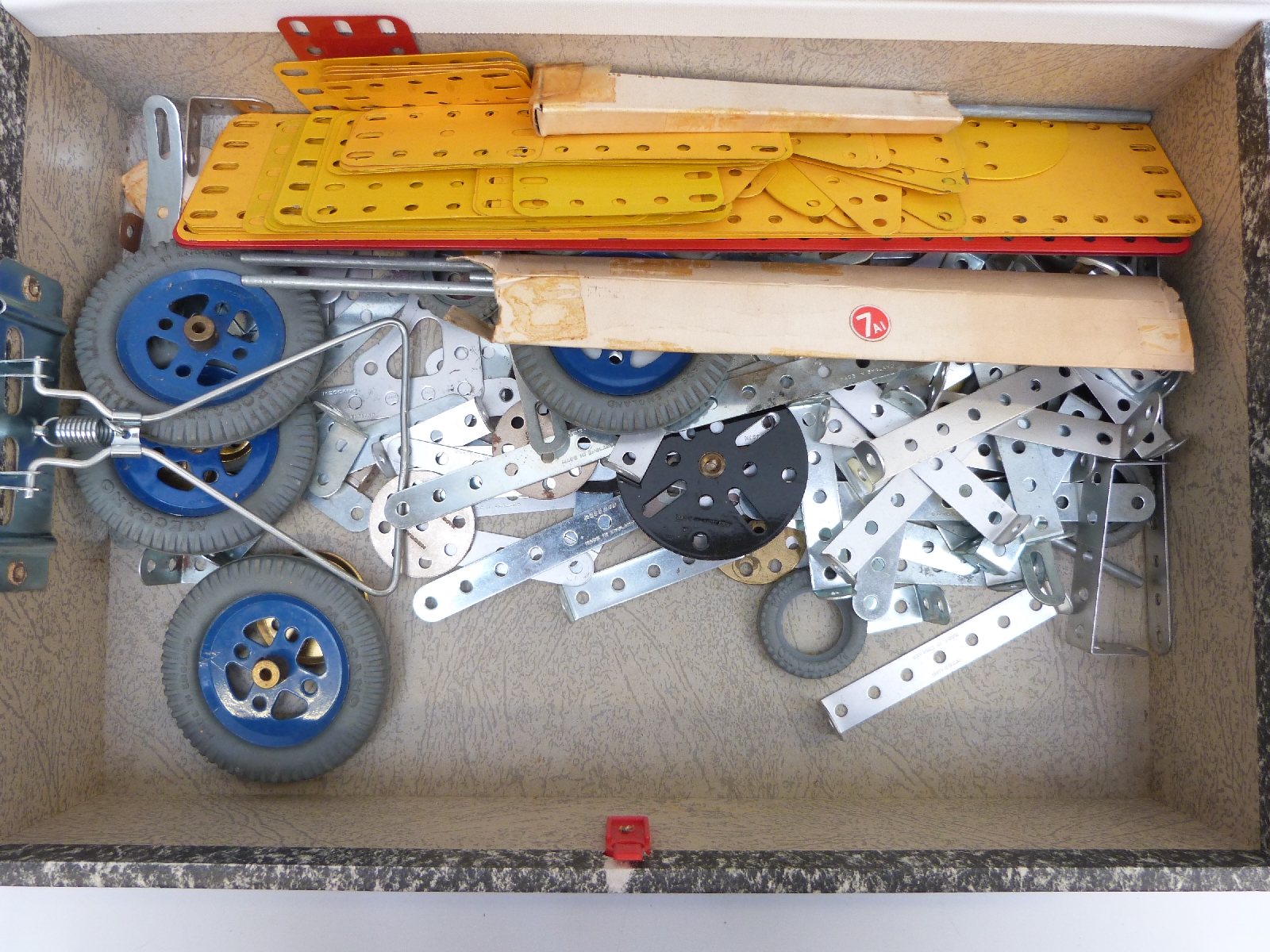 A collection of loose Meccano parts including wheels.