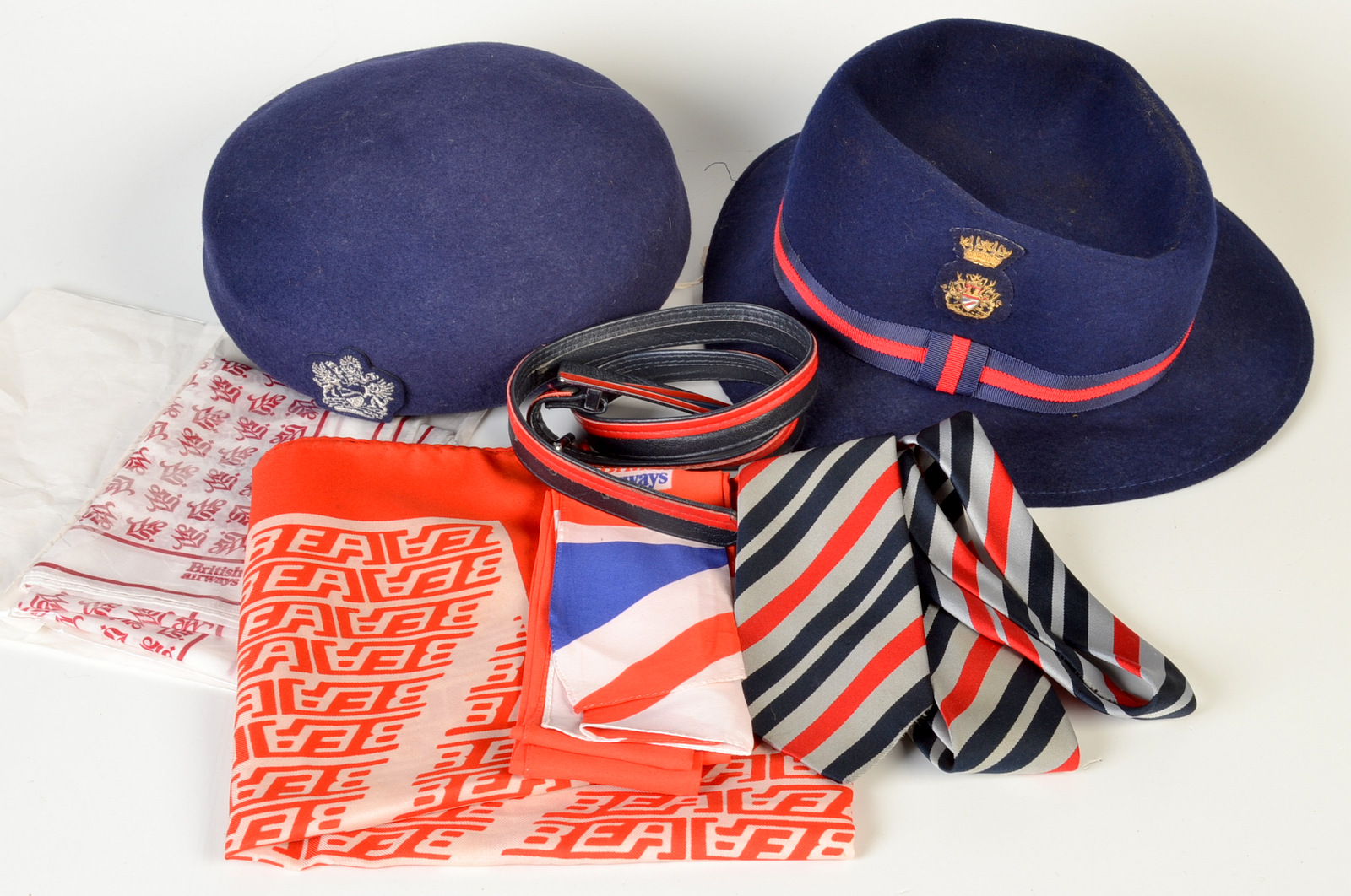 Two British Airways cabin staff hats, together with a related tie, belt ...
