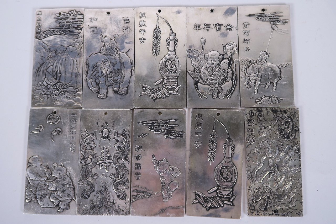 A set of ten Chinese cast white metal tokens decorated with figures and ...