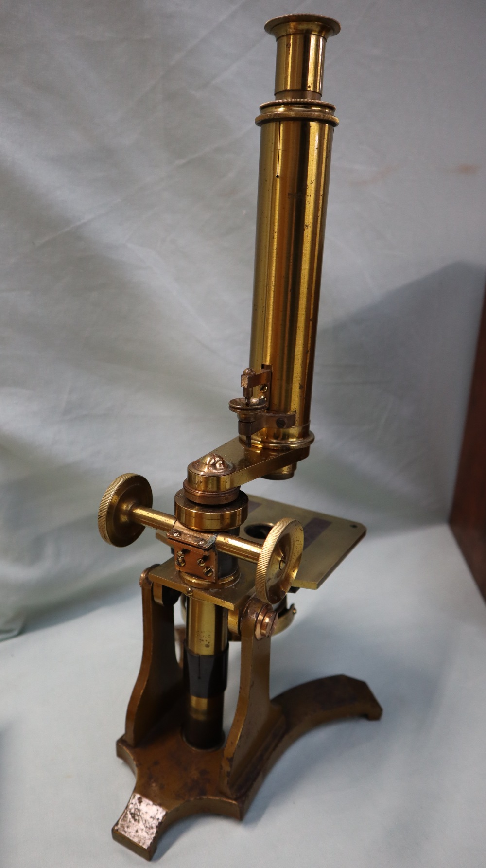 A brass monocular microscope, with rotating mirror, adjustable platform ...
