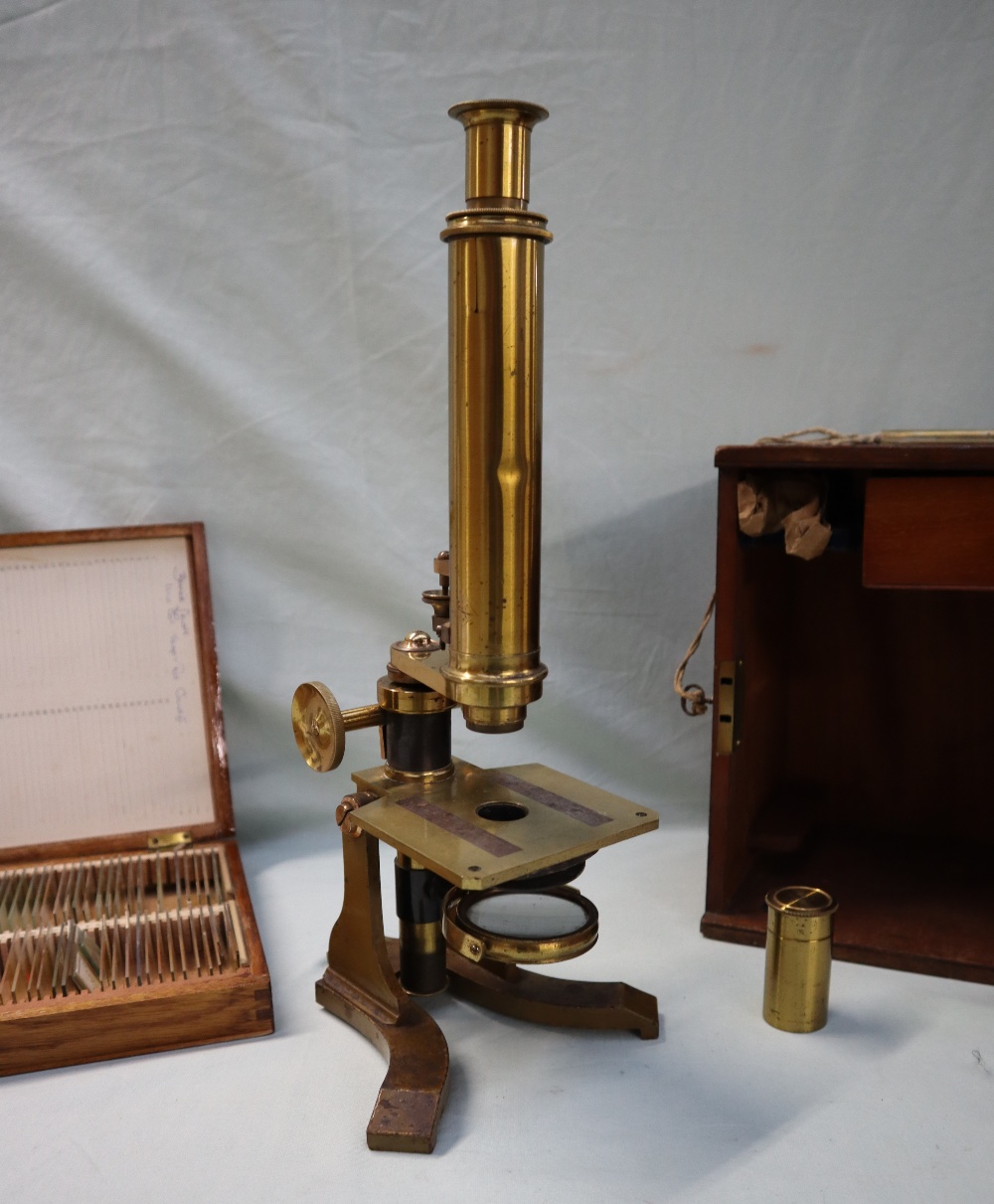 A brass monocular microscope, with rotating mirror, adjustable platform ...