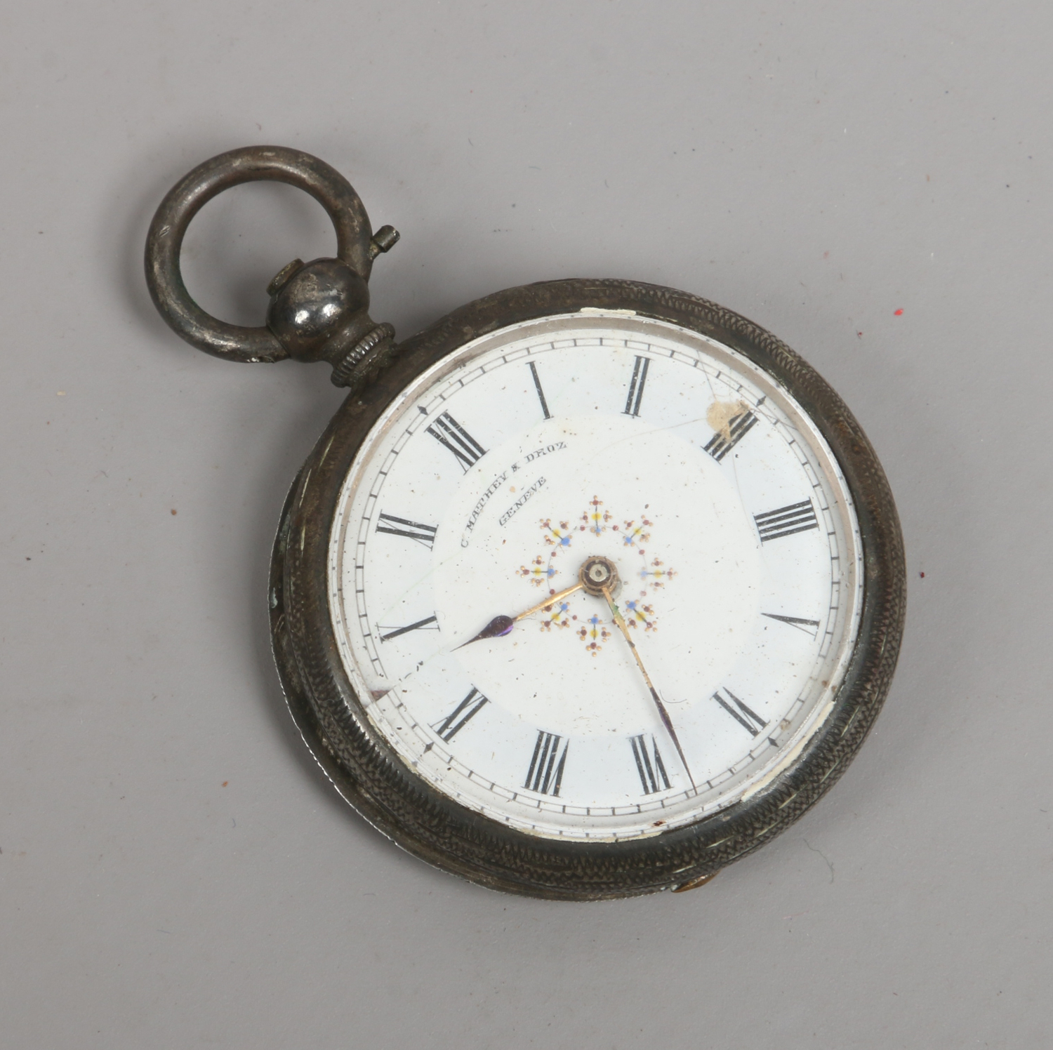 An antique silver fob watch with white enamel dial.