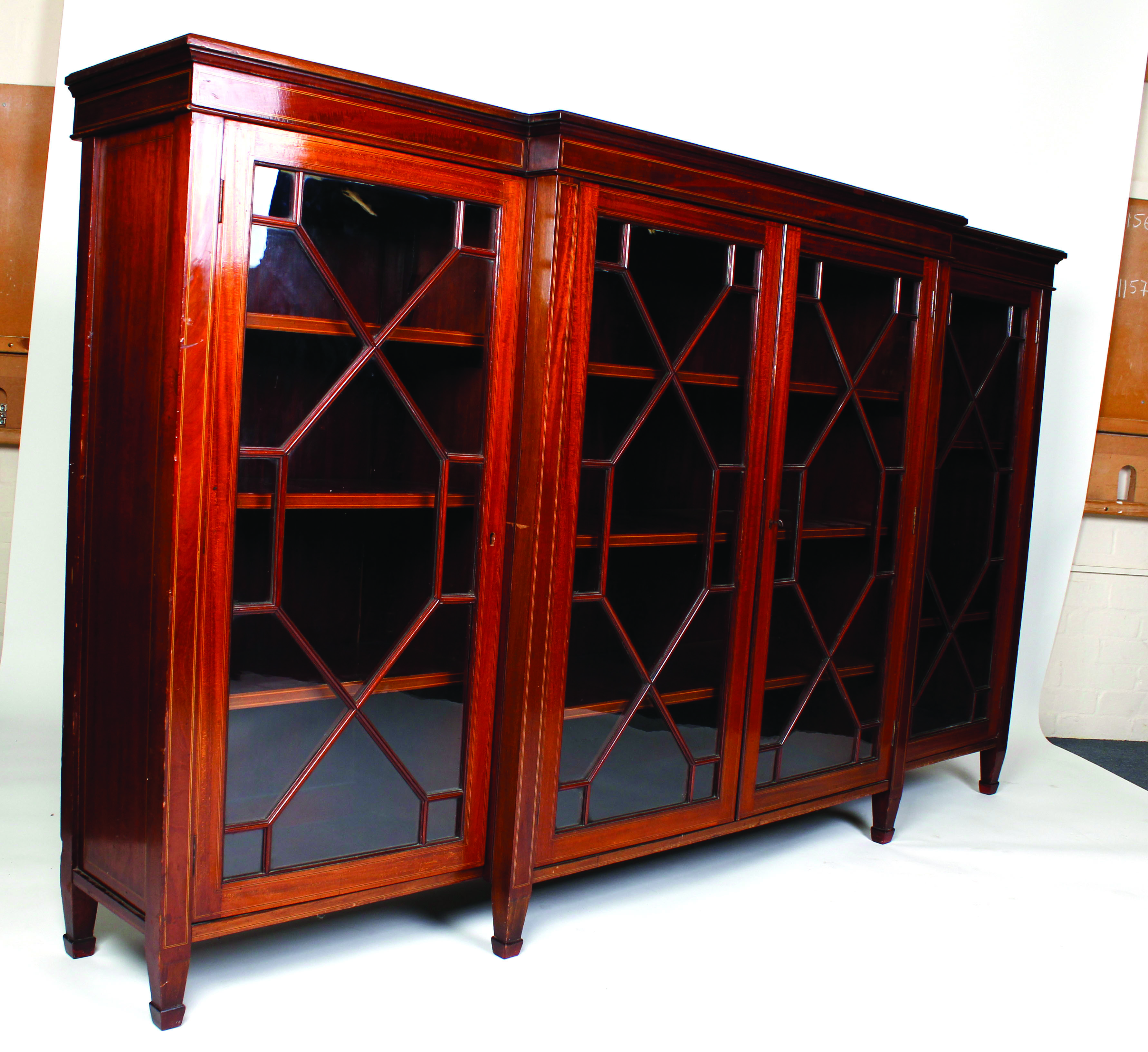 An Edwardian mahogany and strung break-front bookcase, the four ...