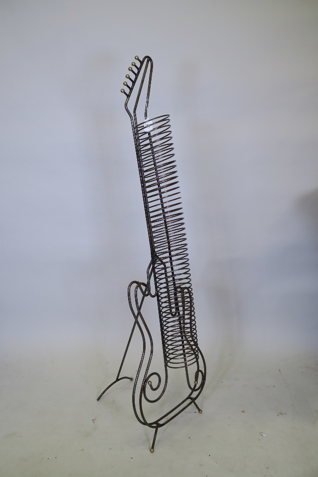 A wrought steel CD rack in the form of a guitar, 53" high