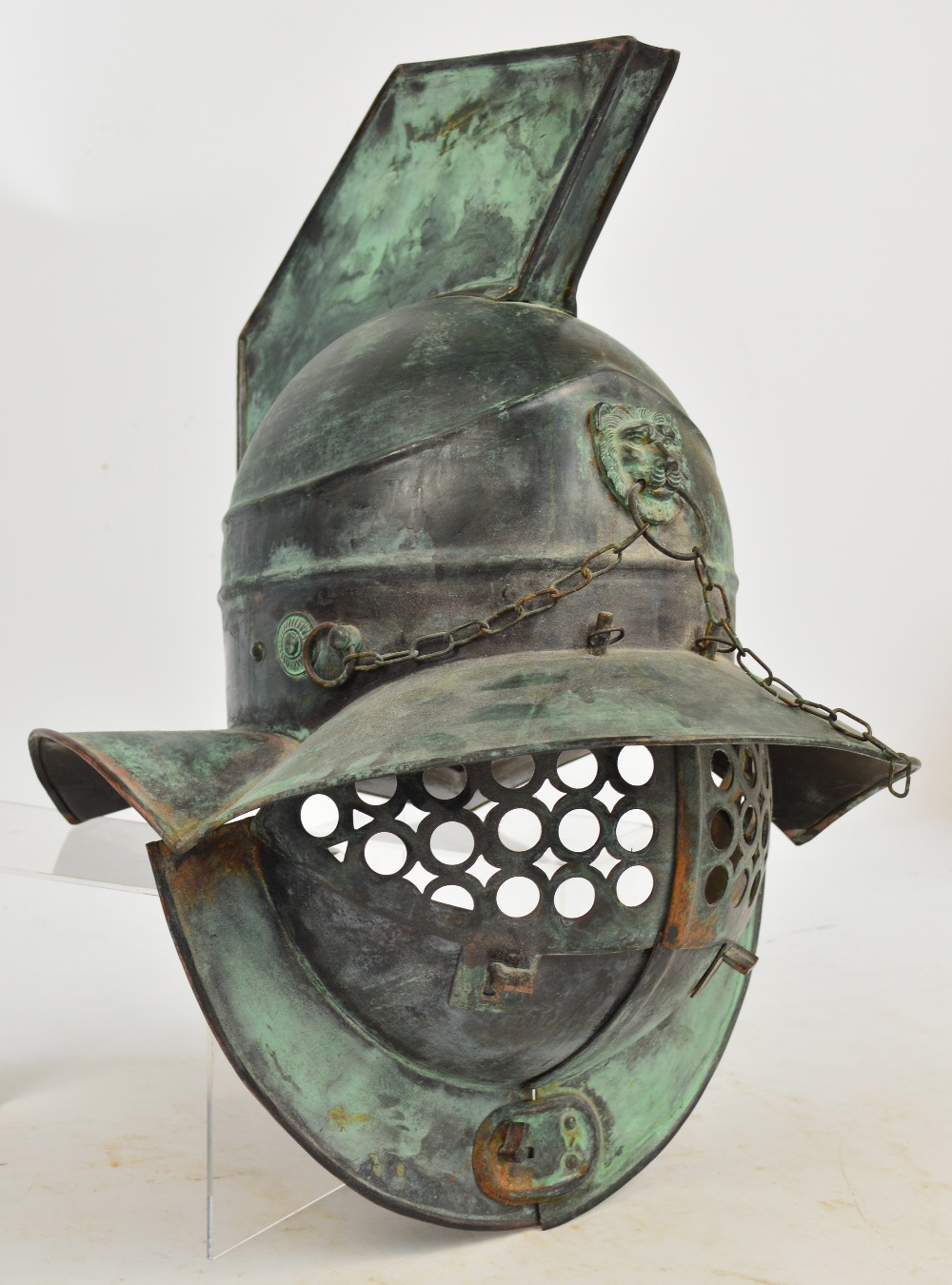 A replica Roman gladiator helmet with lion mask decoration and pierced ...
