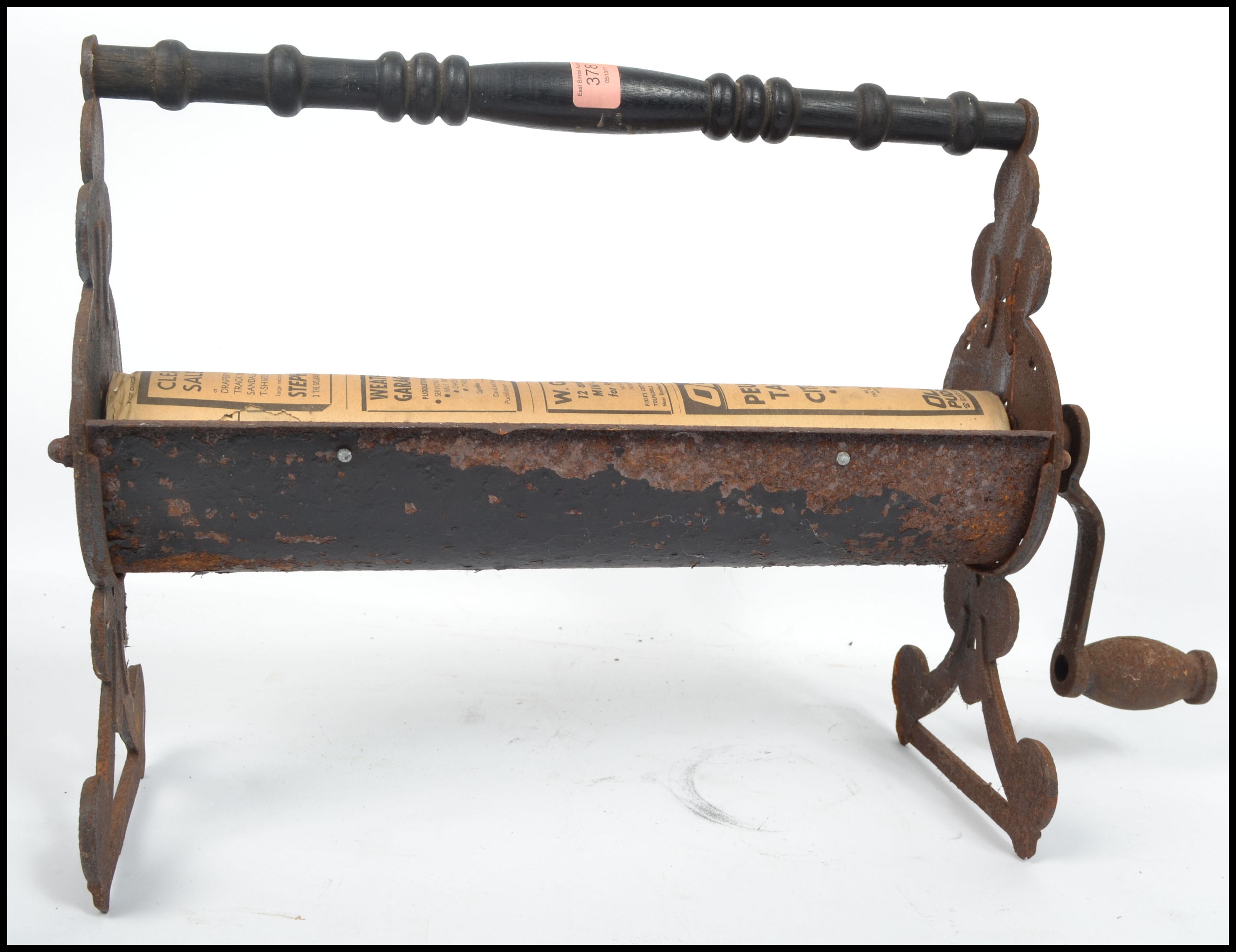 A vintage cast iron newspaper log roller, cast from iron with a central ...