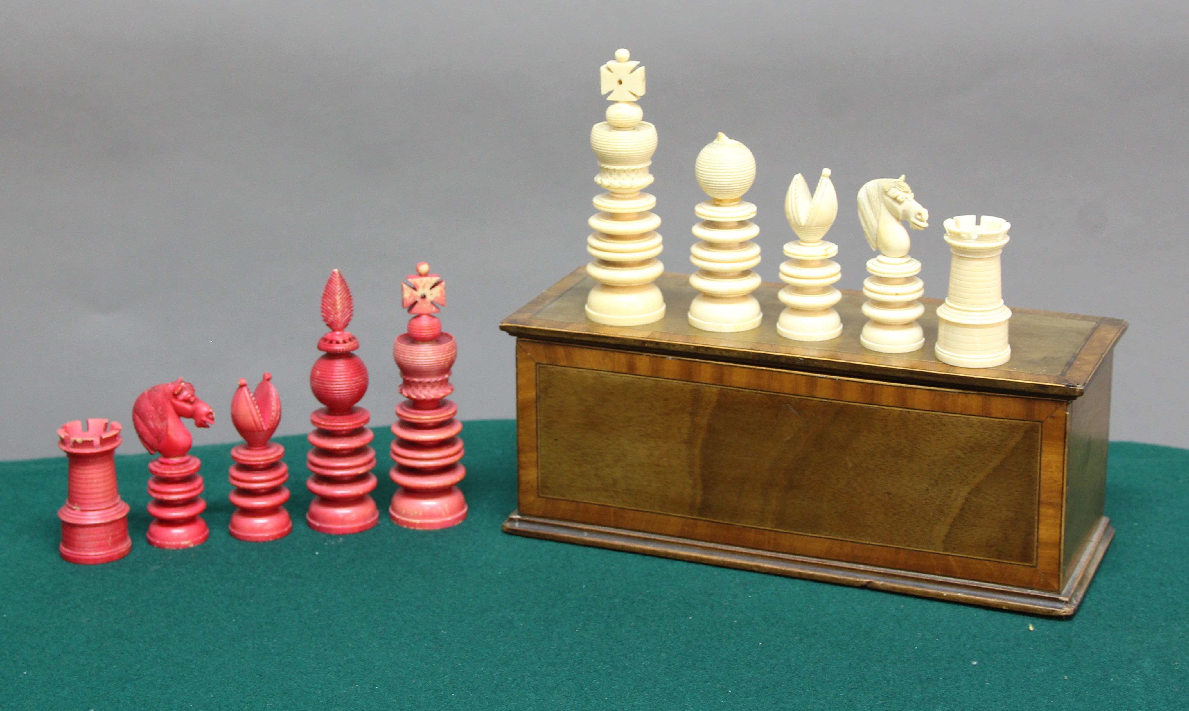 TURNED AND CARVED IVORY CHESS SET, late 19th century, natural and red ...