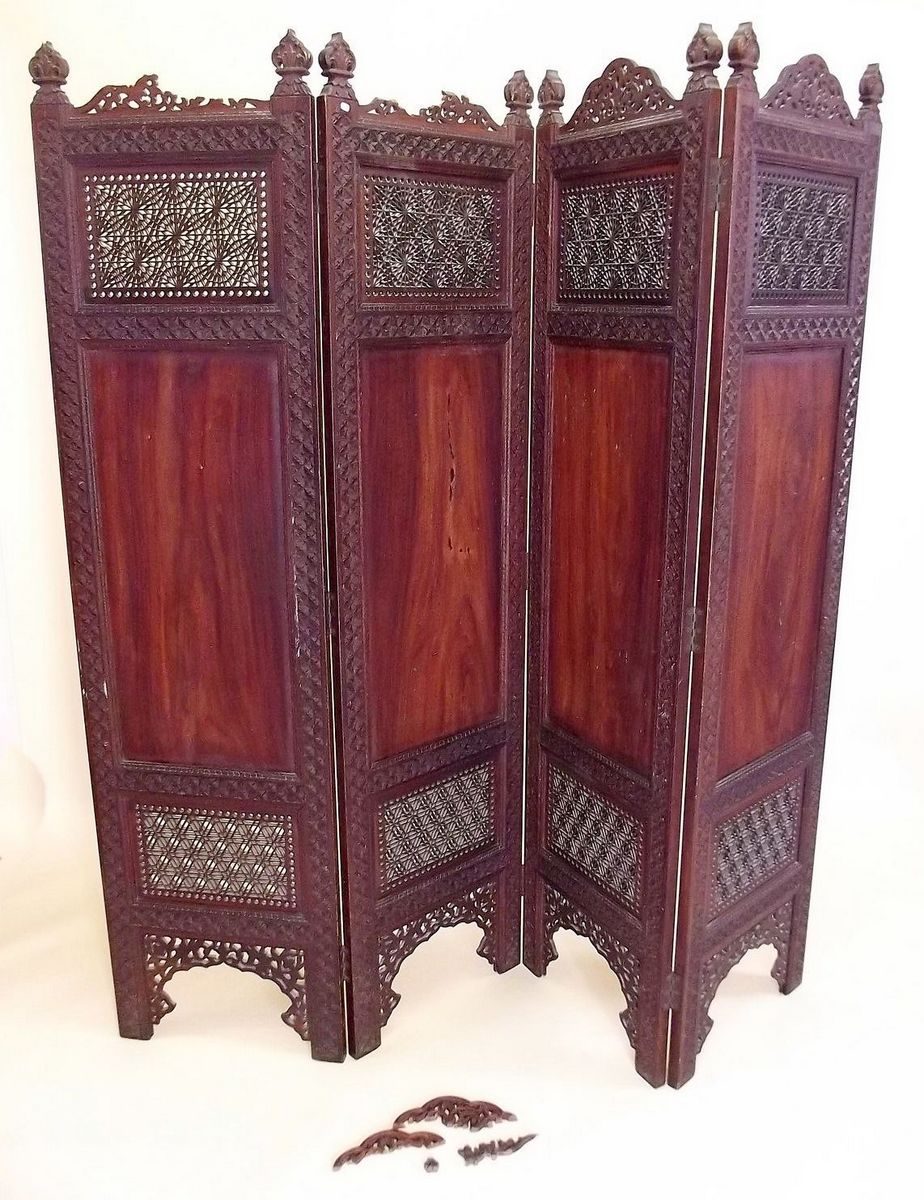 An Indian rosewood four fold screen with pierced and carved panels and ...