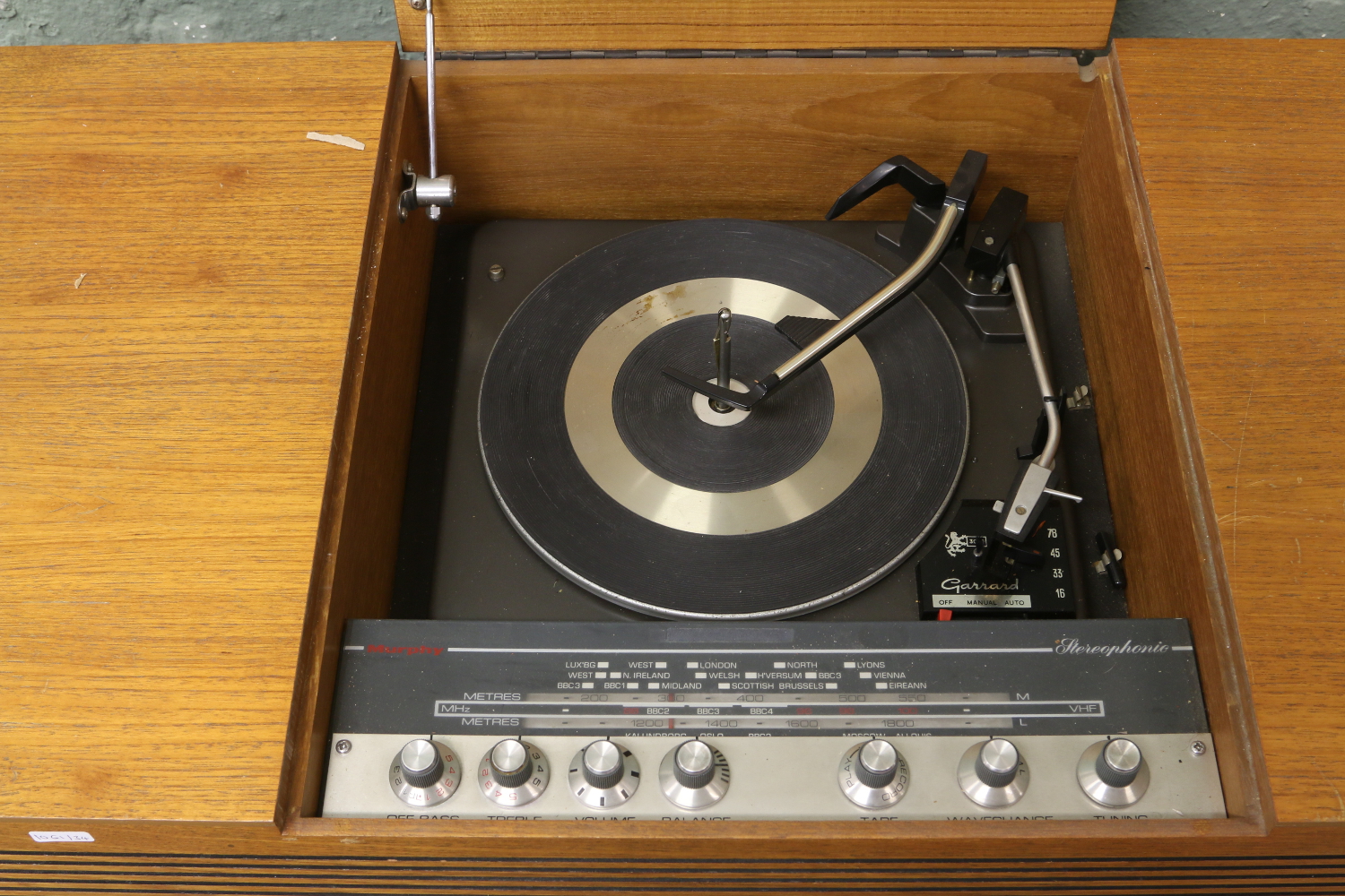 A 1970s teak retro stereo radiogram with 4 speed Garrard turn table.