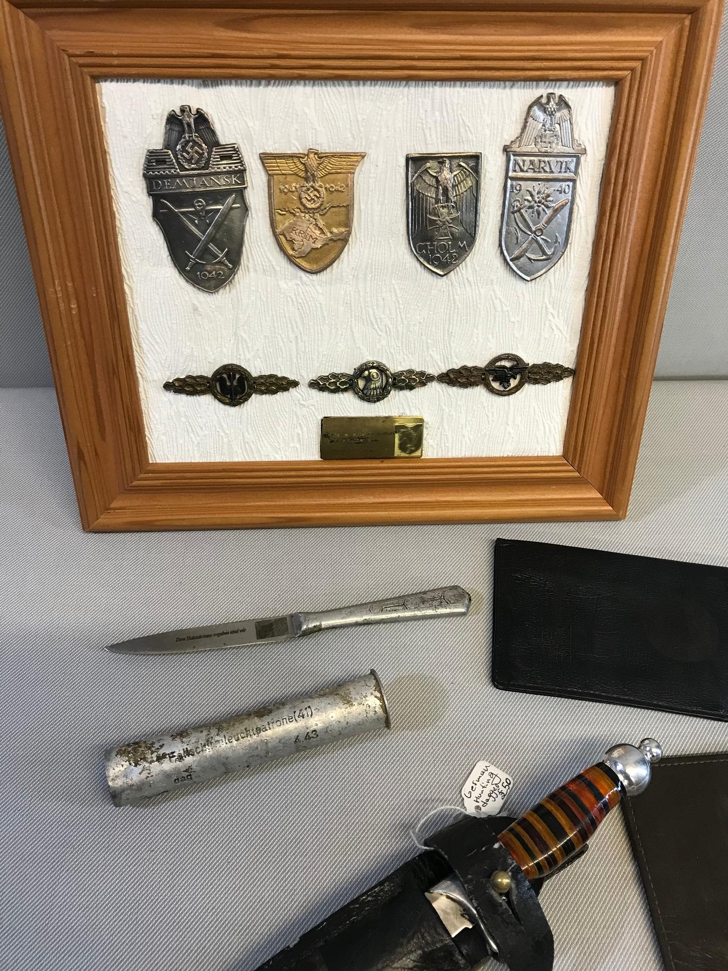 A Collection of replica German Nazi items which includes cap badges ...