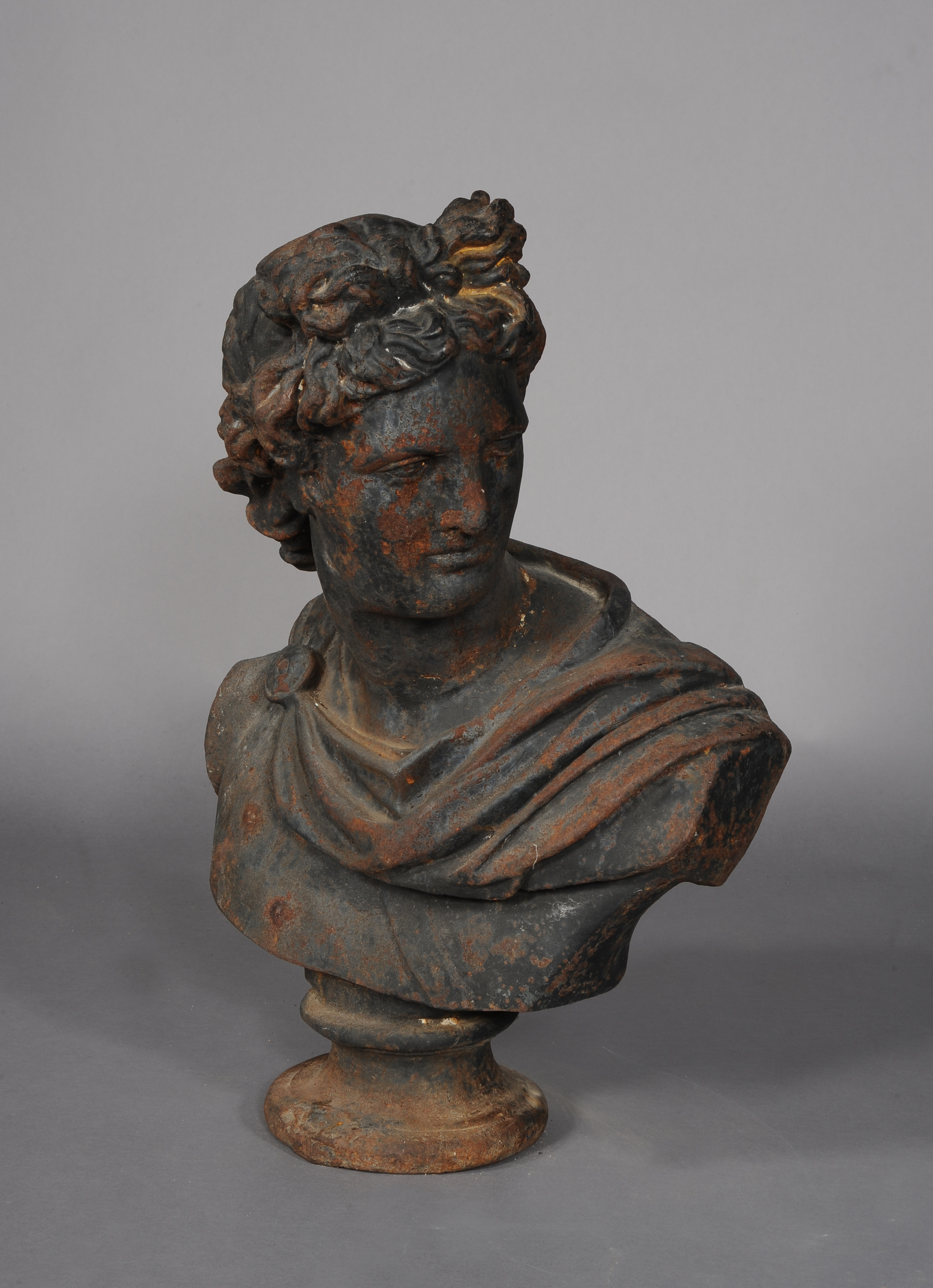 A 19TH CENTURY CAST IRON BUST OF APOLLO, after the Roman marble known ...