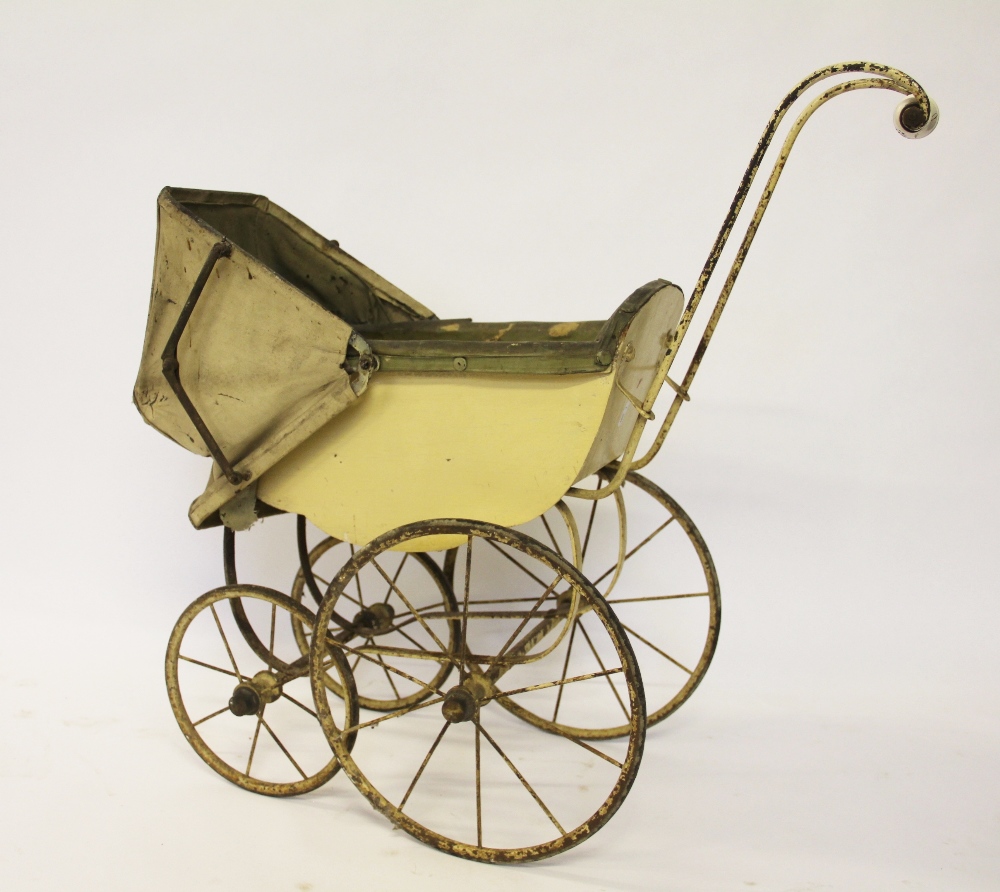 A Victorian dolls pram, with padded interior upon four spindle wheels ...