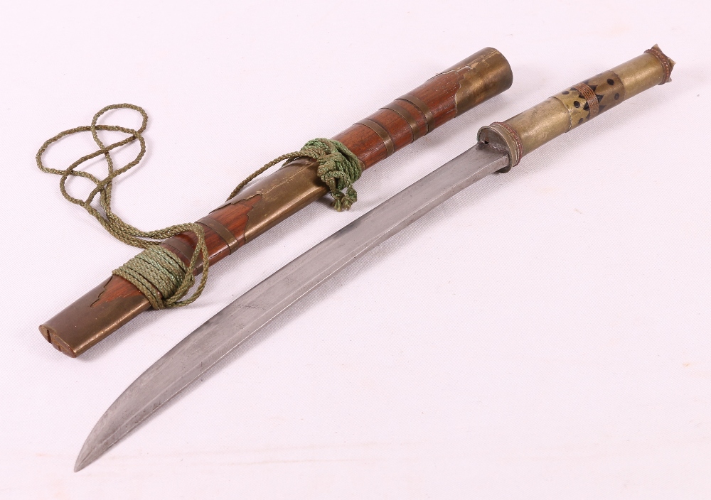A Japanese dagger with curved blade, decorated brass handle and a brass ...