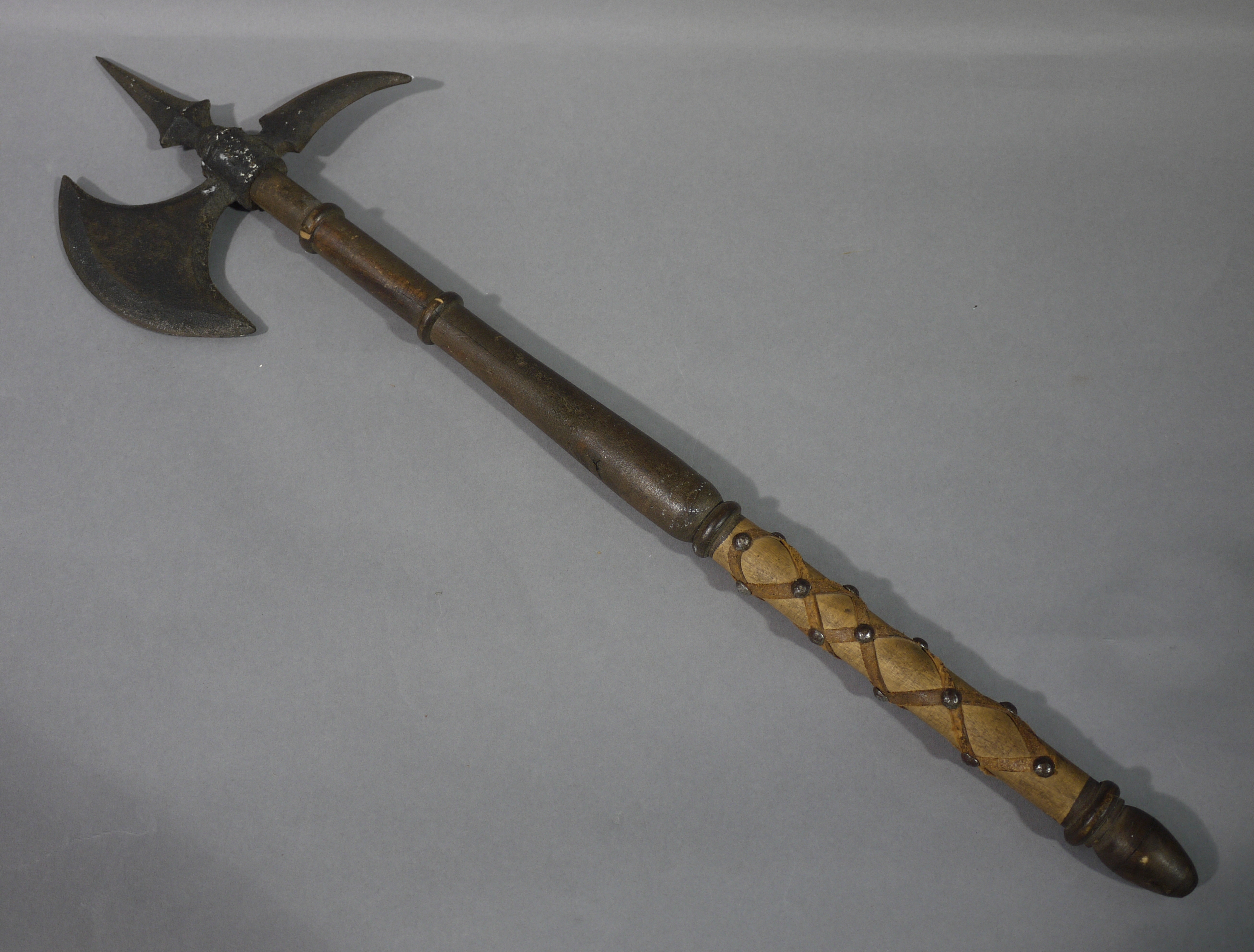 A reproduction medieval axe with curved blade on a leather wrapped shaft