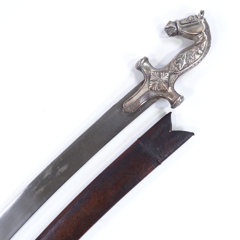 An Indian curved sword, with horsehead design hilt and lion and buffalo ...