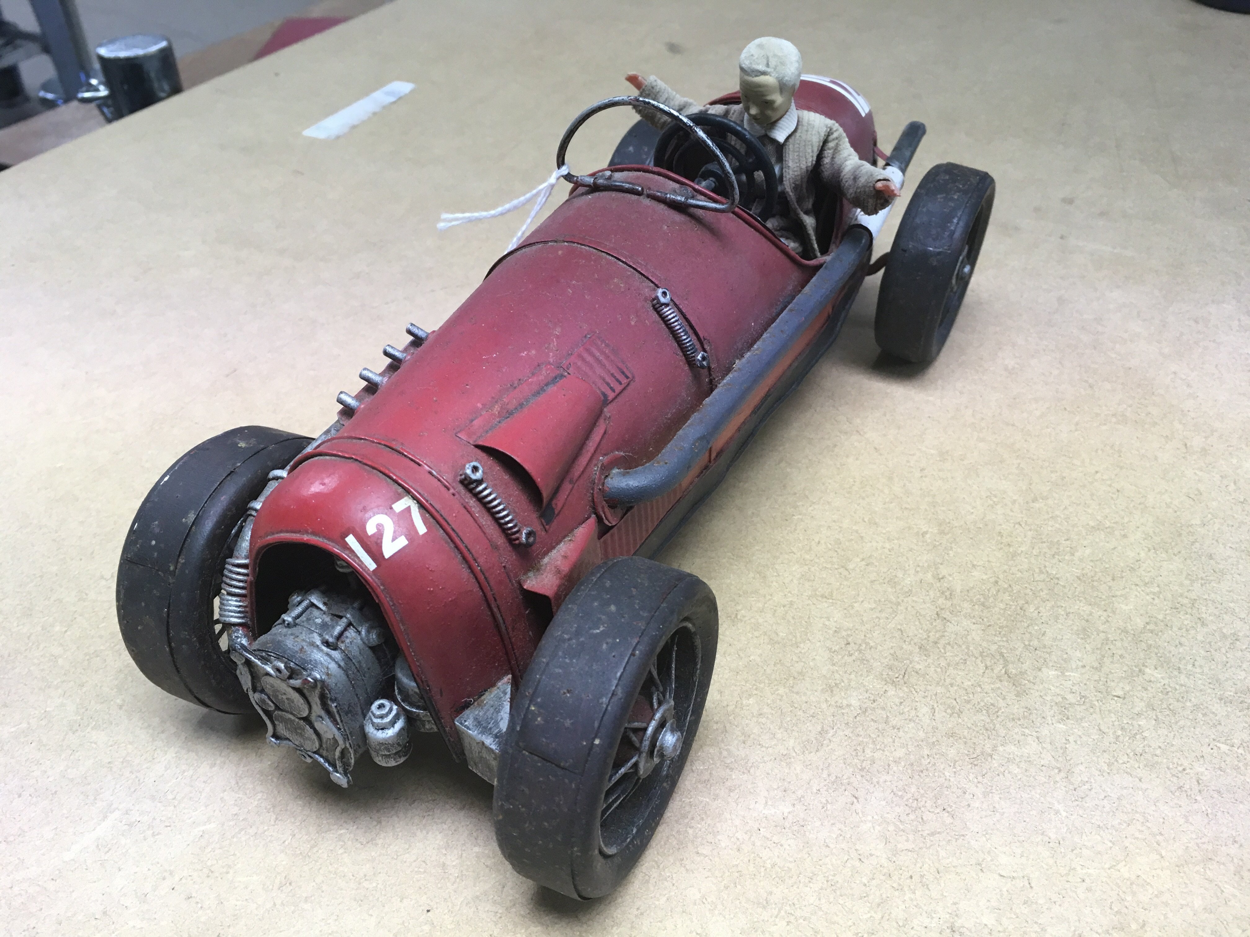 A metal model of a racing car with driver.