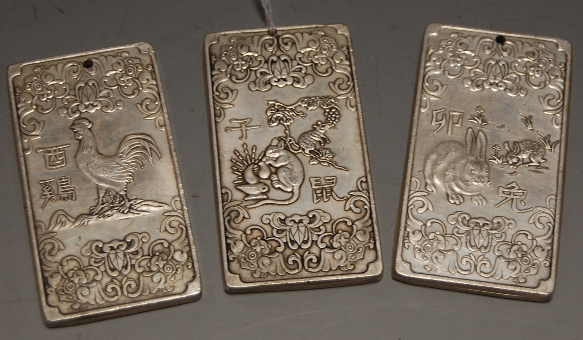 A set of three Chinese white metal trade tokens each of rectangular ...